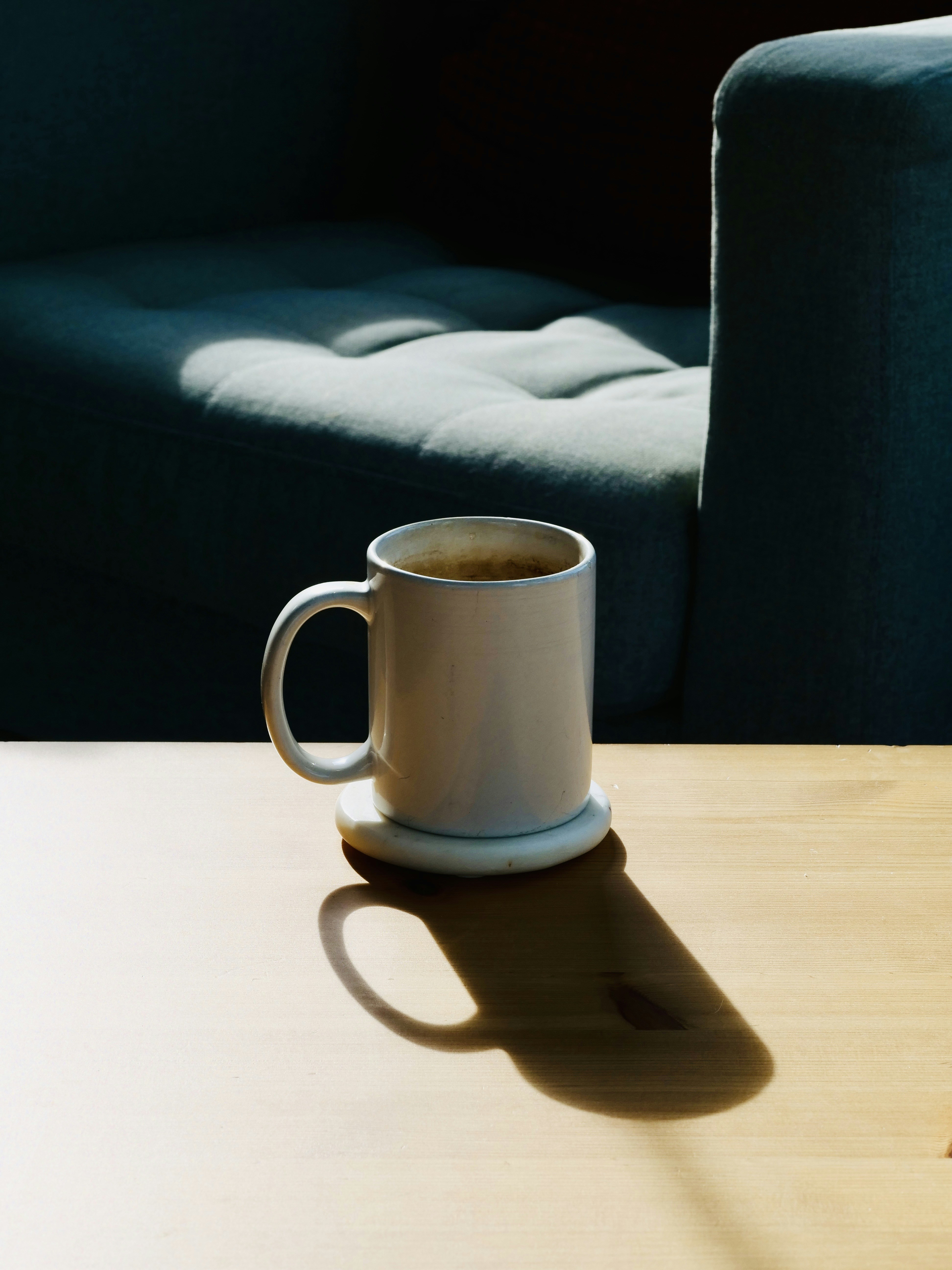 Sunlit Mug Casting a Quiet Shadow on Wood