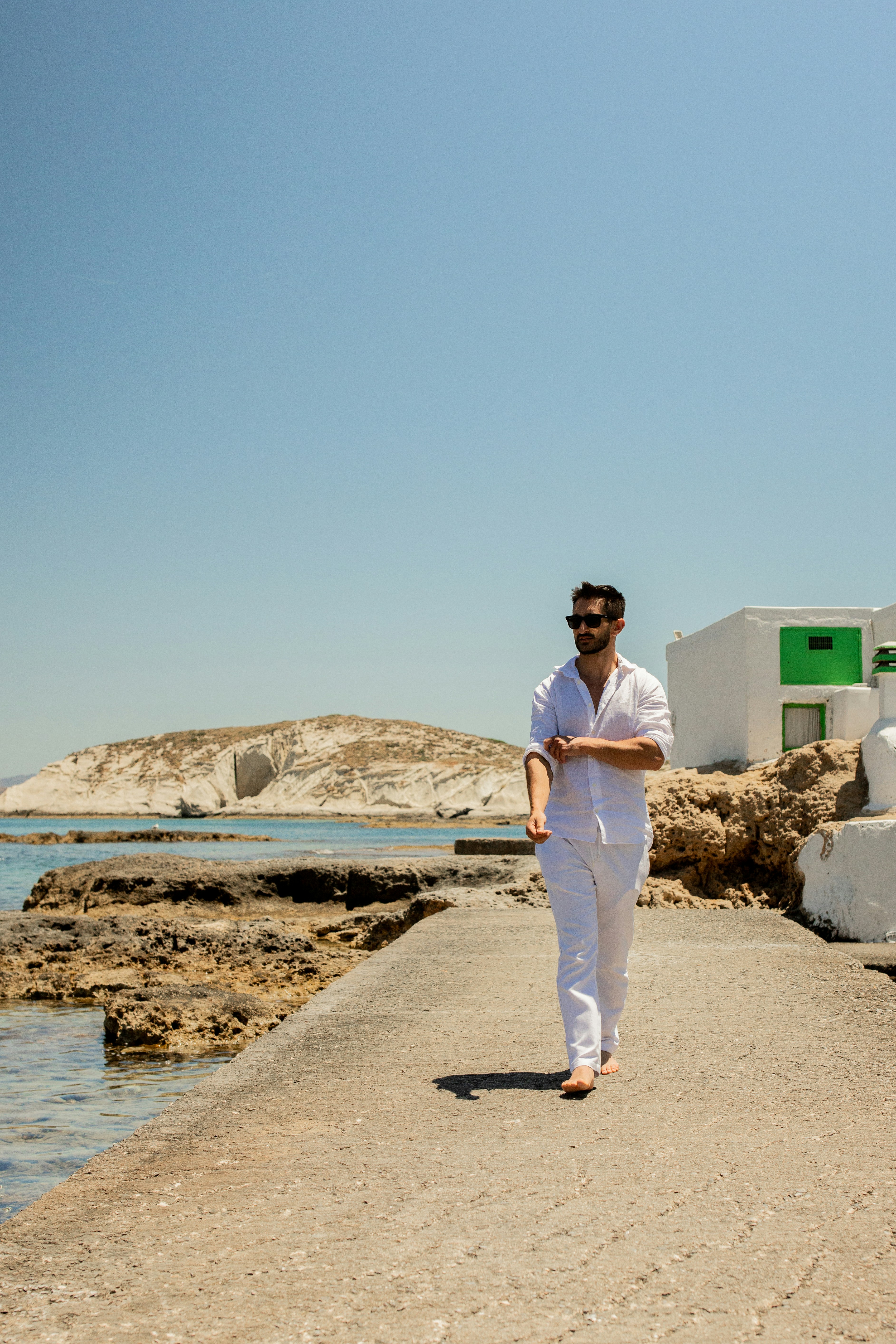 White Attire, Blue Sky: A Quiet Walk on a Sea-Edge Pier
