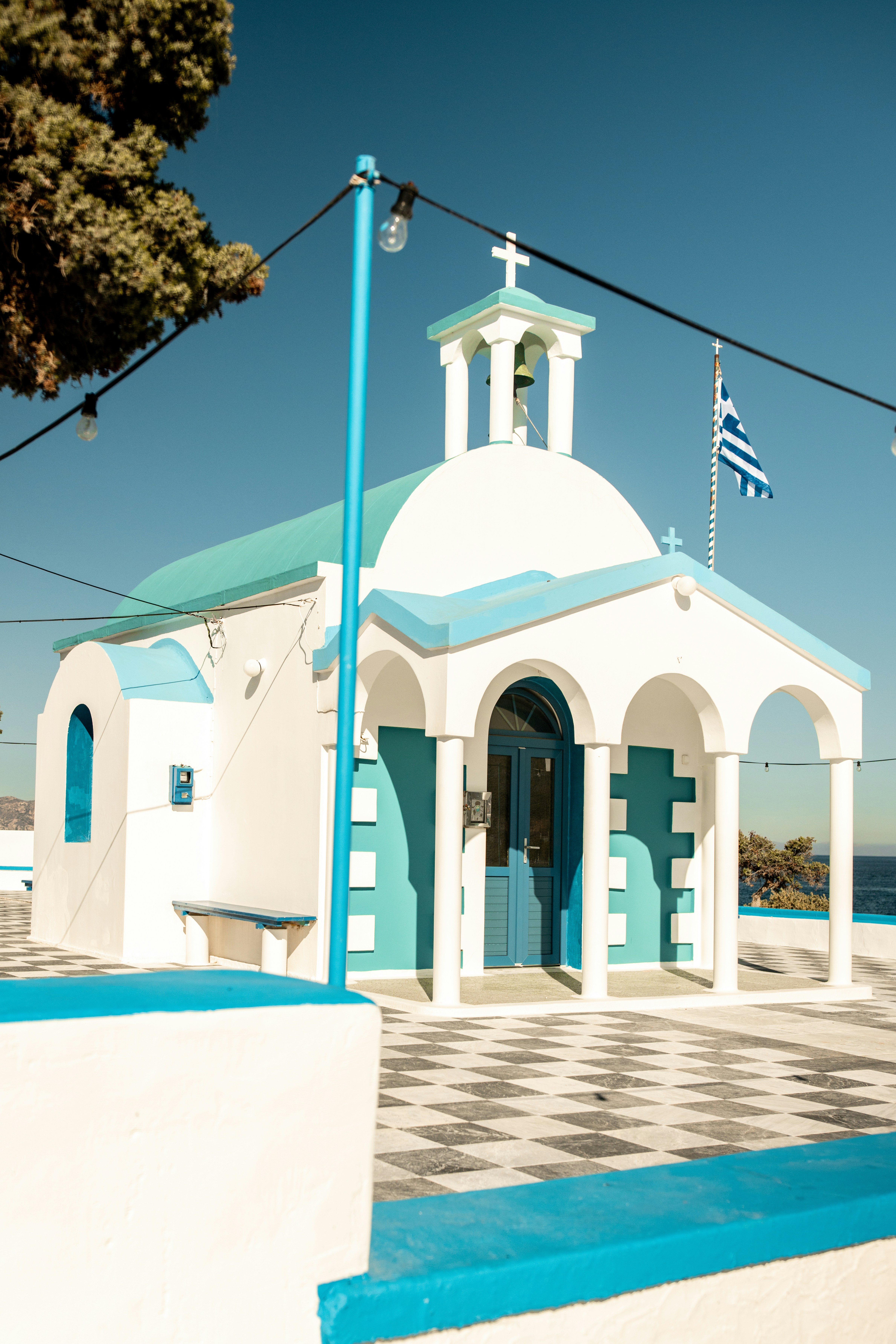 Whitewashed Orthodox Chapel with Teal Accents Under Clear Sky