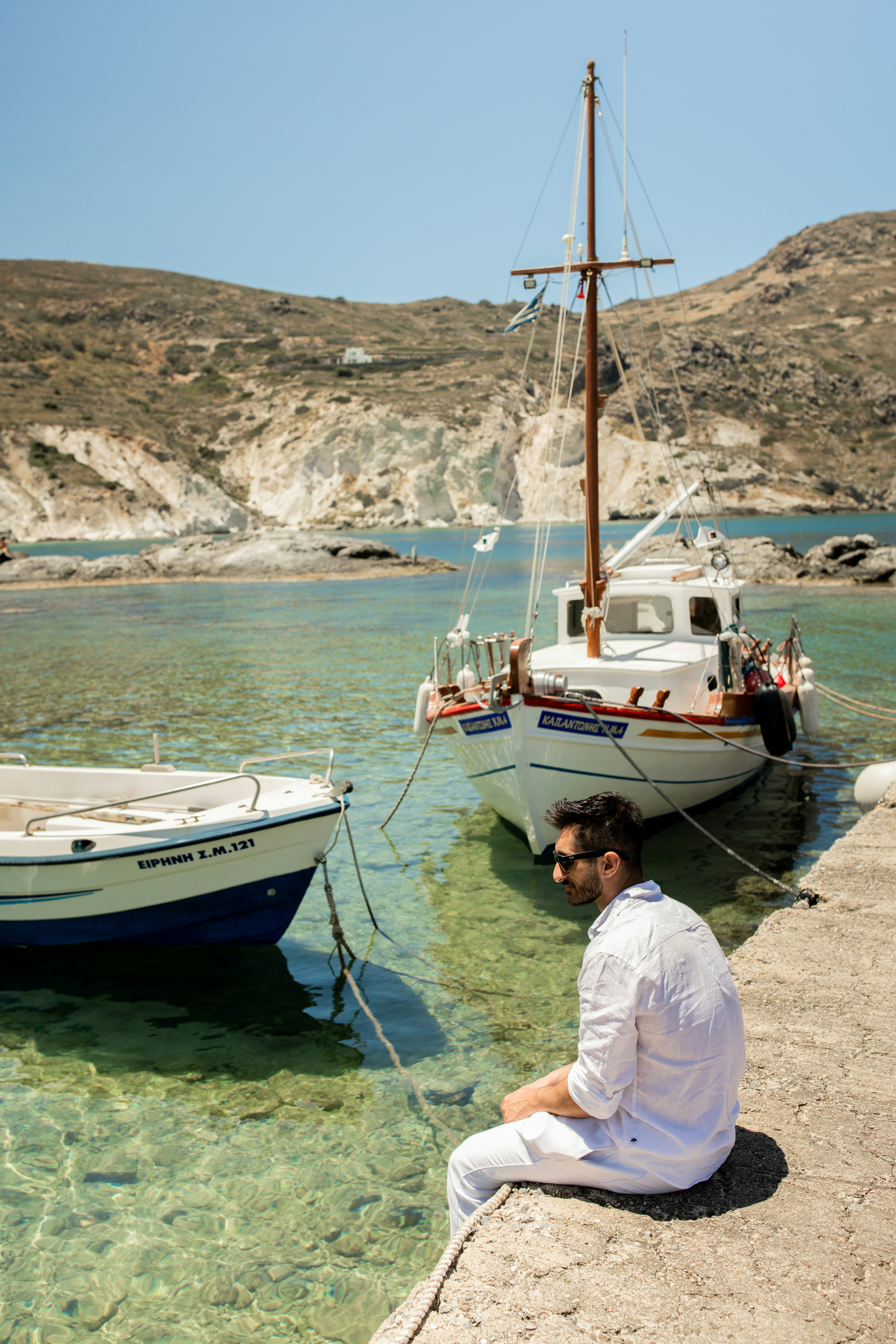 Sailor in White: A Quiet Moment at the Harbor’s Edge