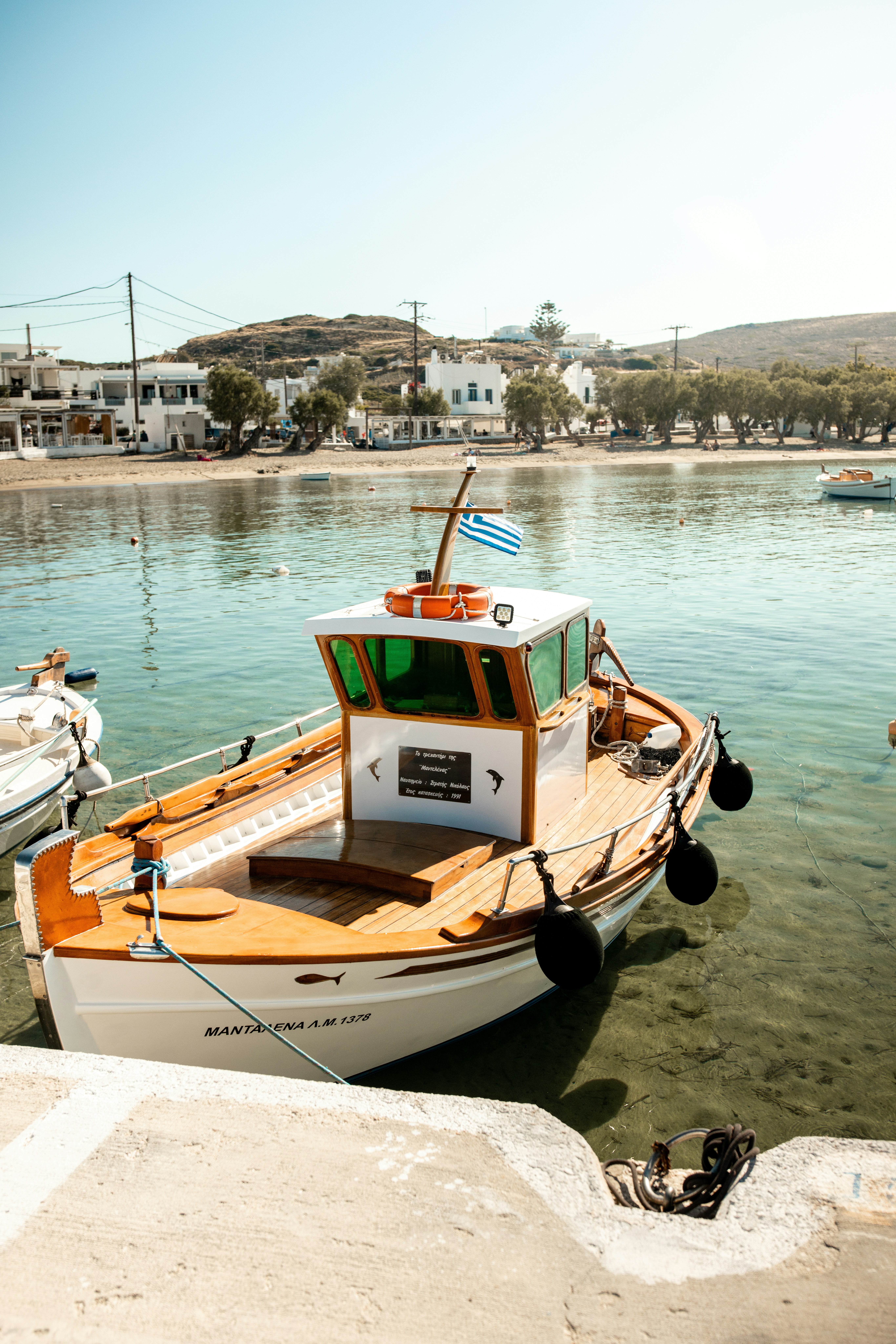 Coastal Hopper: A Classic Boat Resting at Sunny Harbor