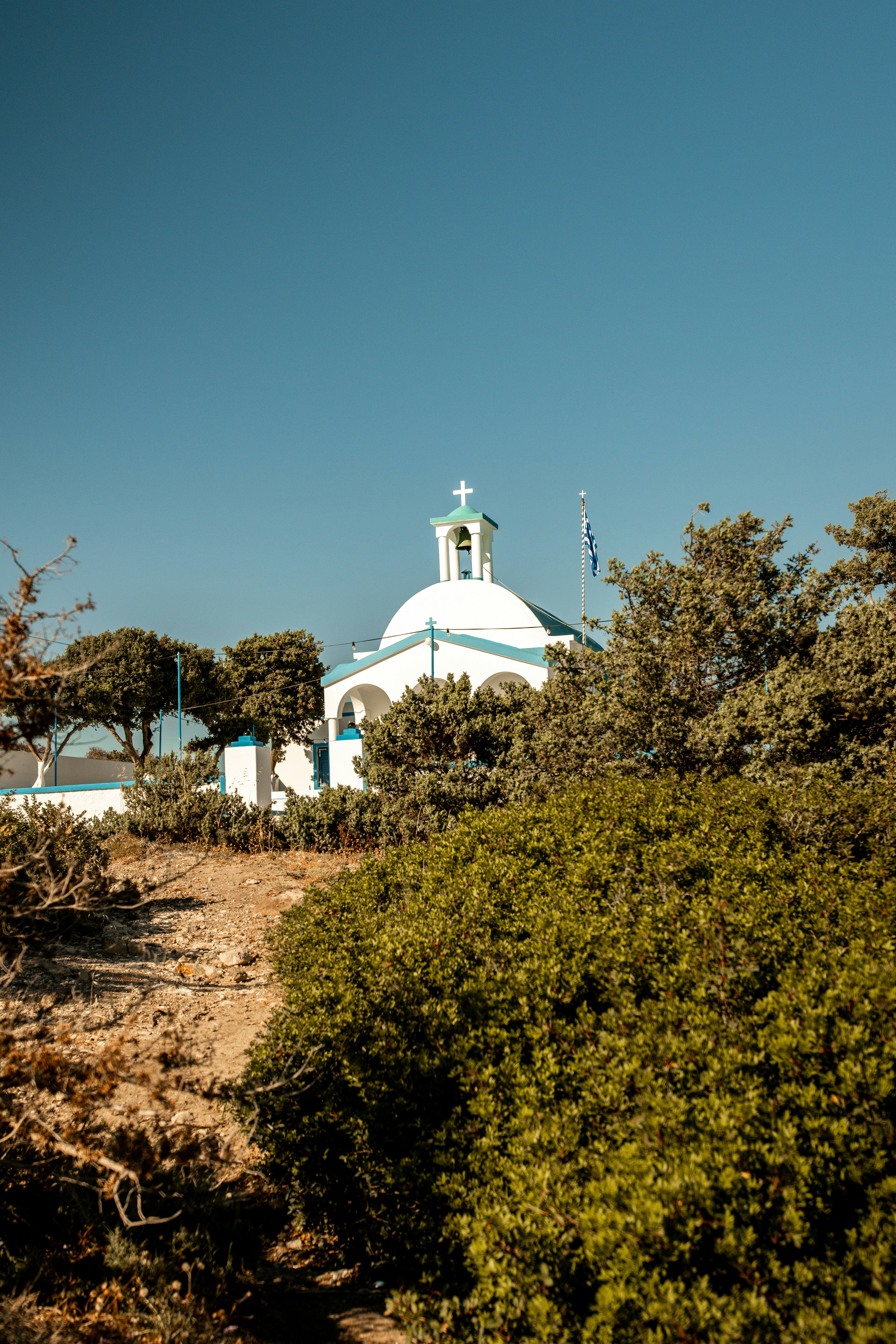 White Chapel Crowned by Blue Sky Above a Shrouded Landscape