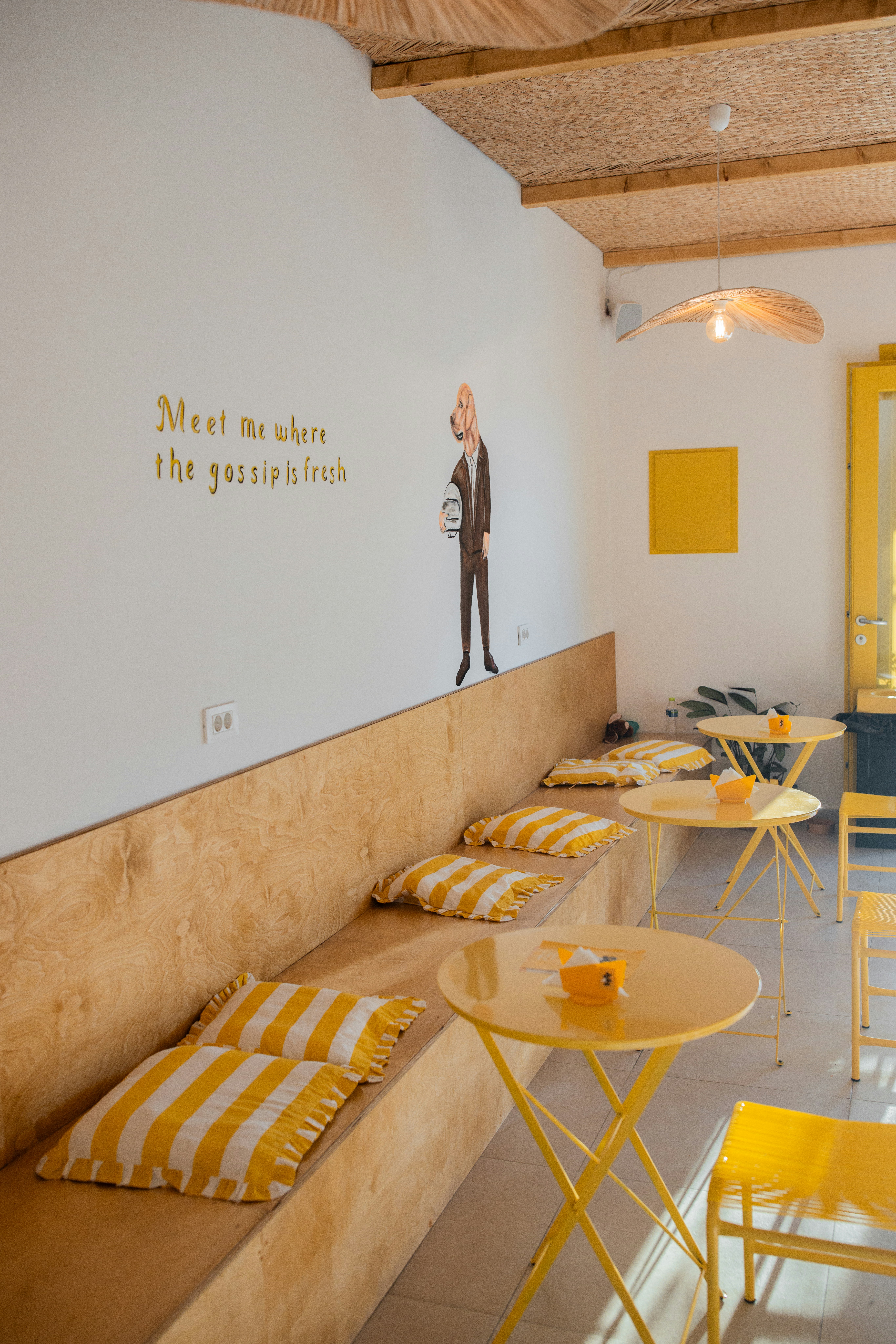 Sunny cafe with striped cushions and whimsical wall art