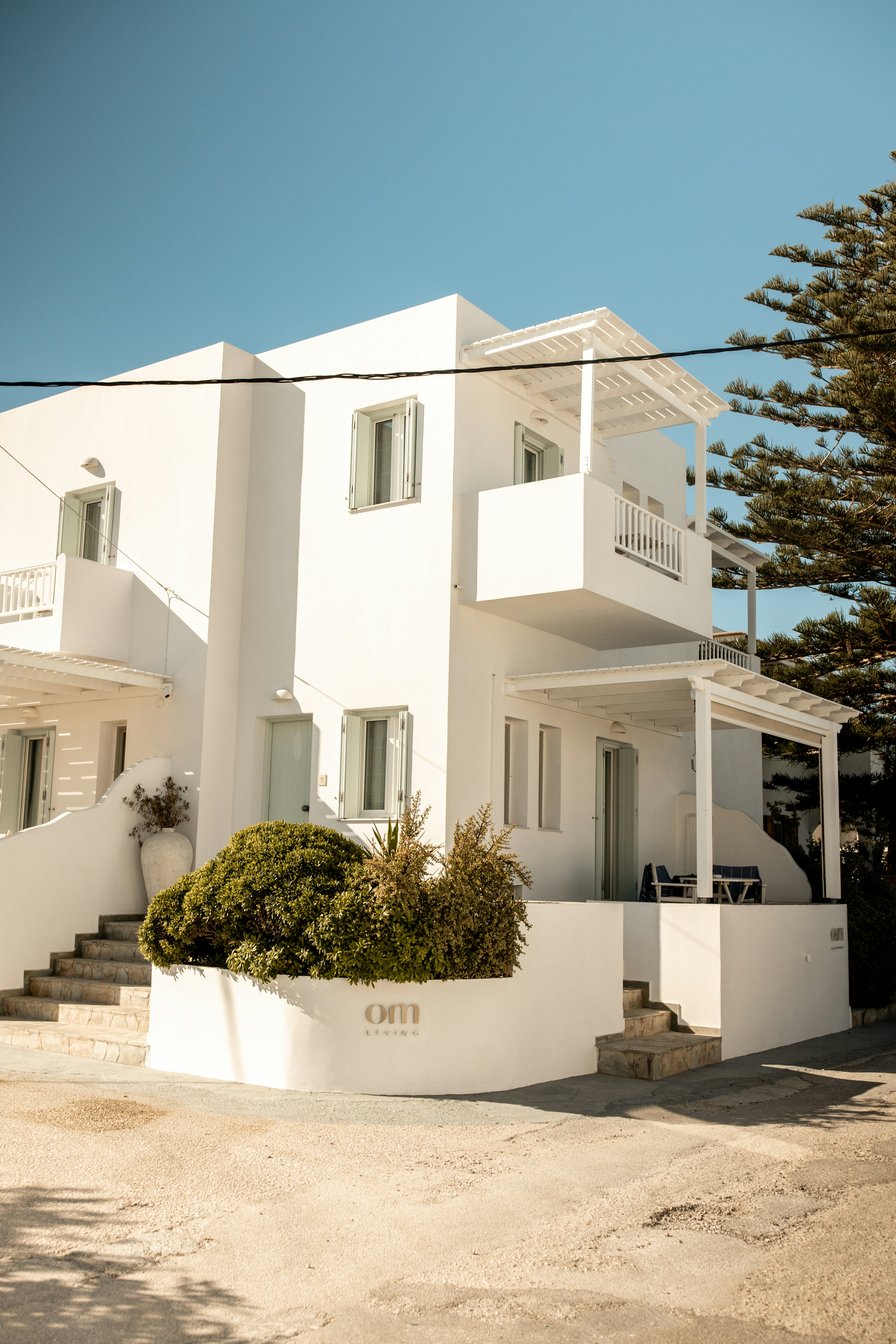Sunlit White Villa with Terraced Entry and Sea-Edge Shadow