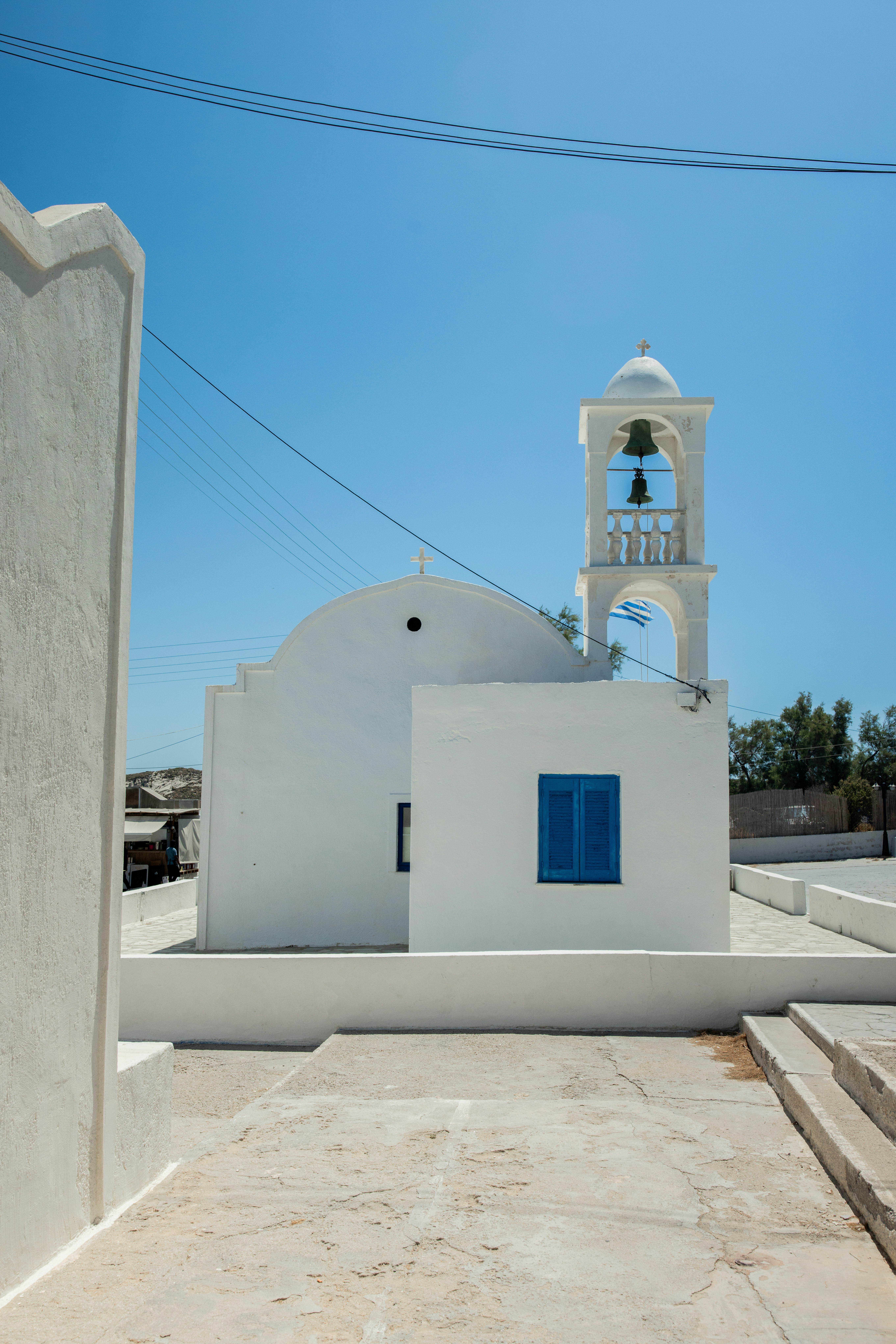Whitewashed Church with Bell Tower Under a Bright Aegean Sky