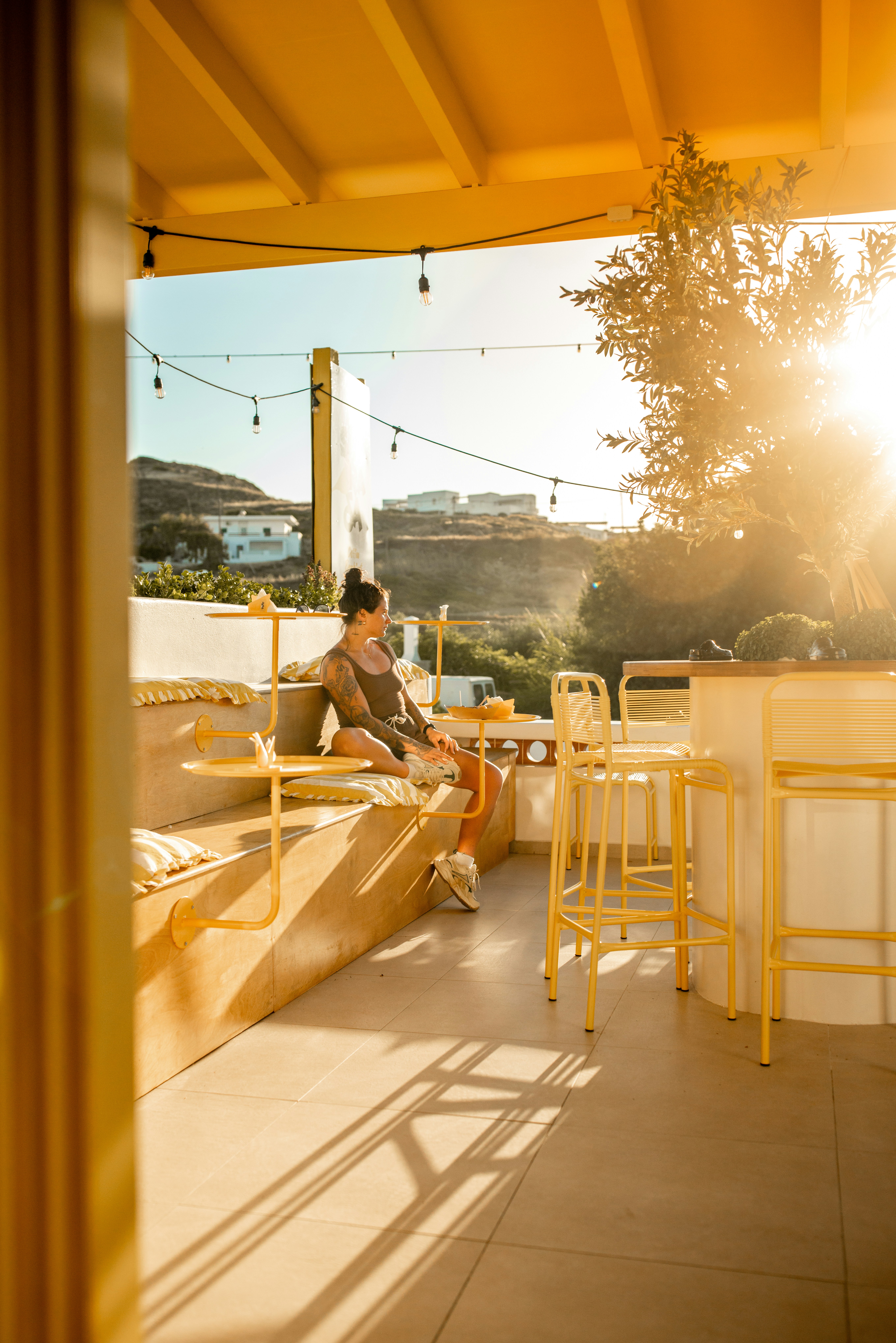Sunlit Terrace: A Tattooed Soul in a Quiet Patio