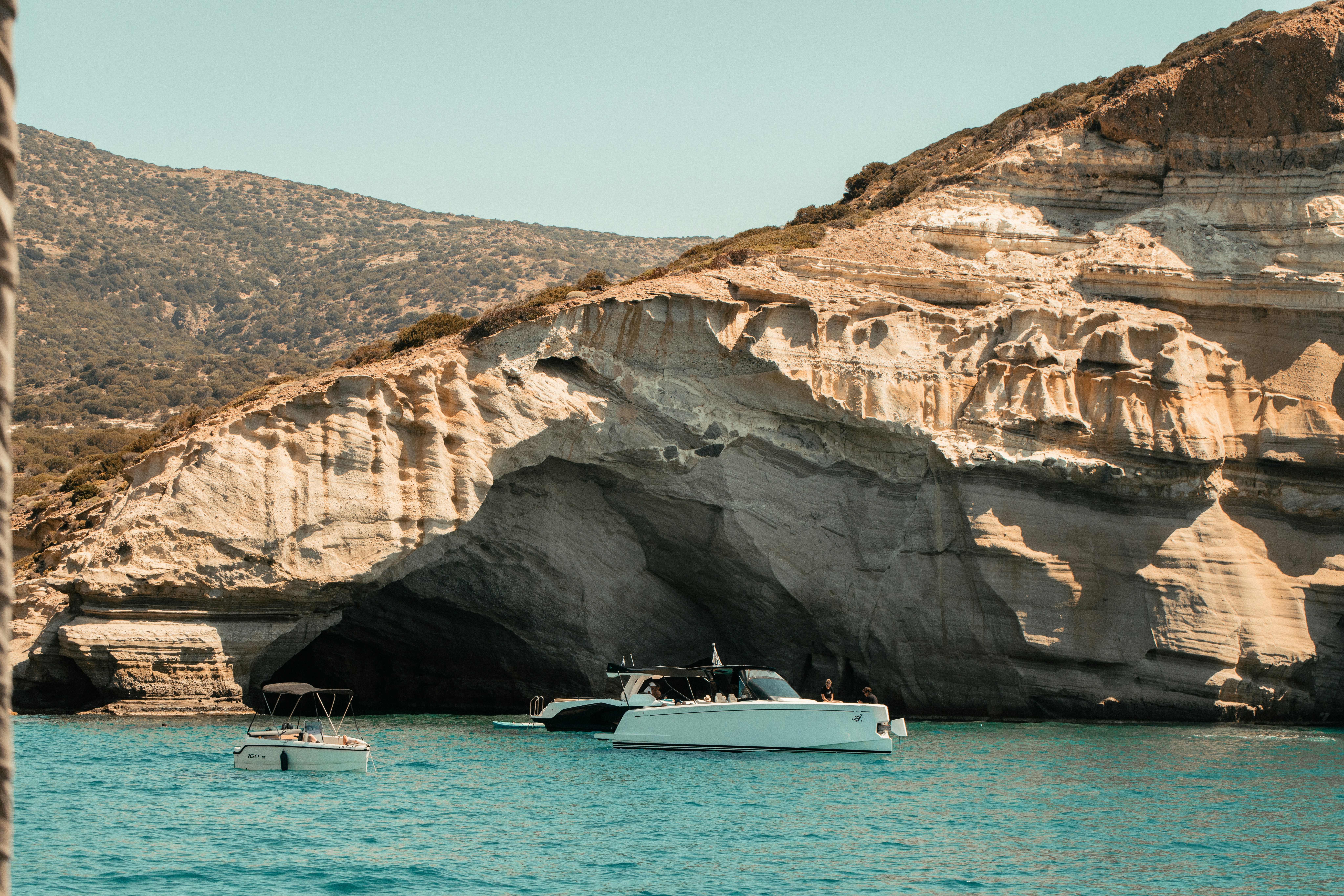 Teal Wake: Boats Resting at the Cliff-Rendered Sea