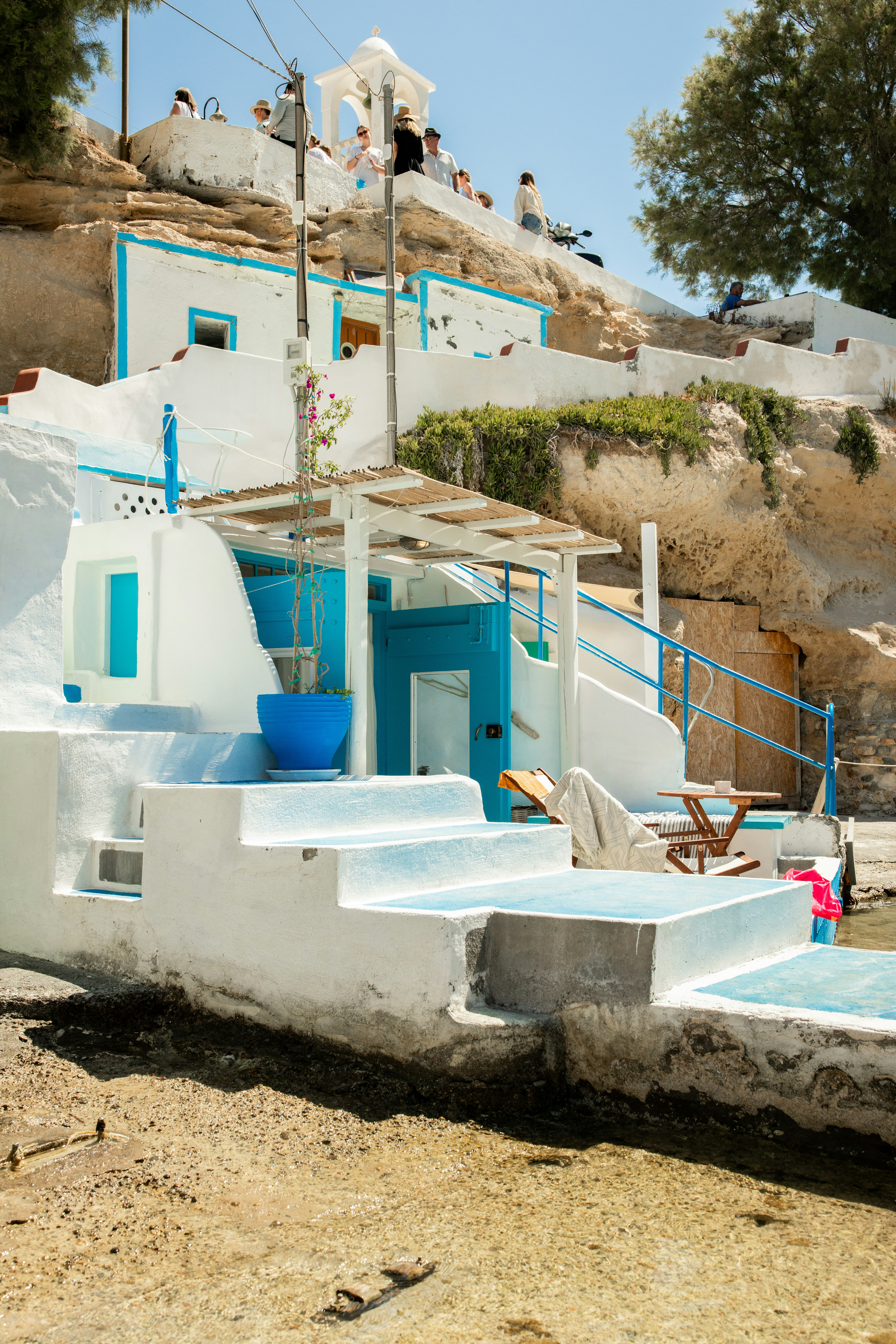 Blue doors and white stairs of a Cycladic terrace by the sea
