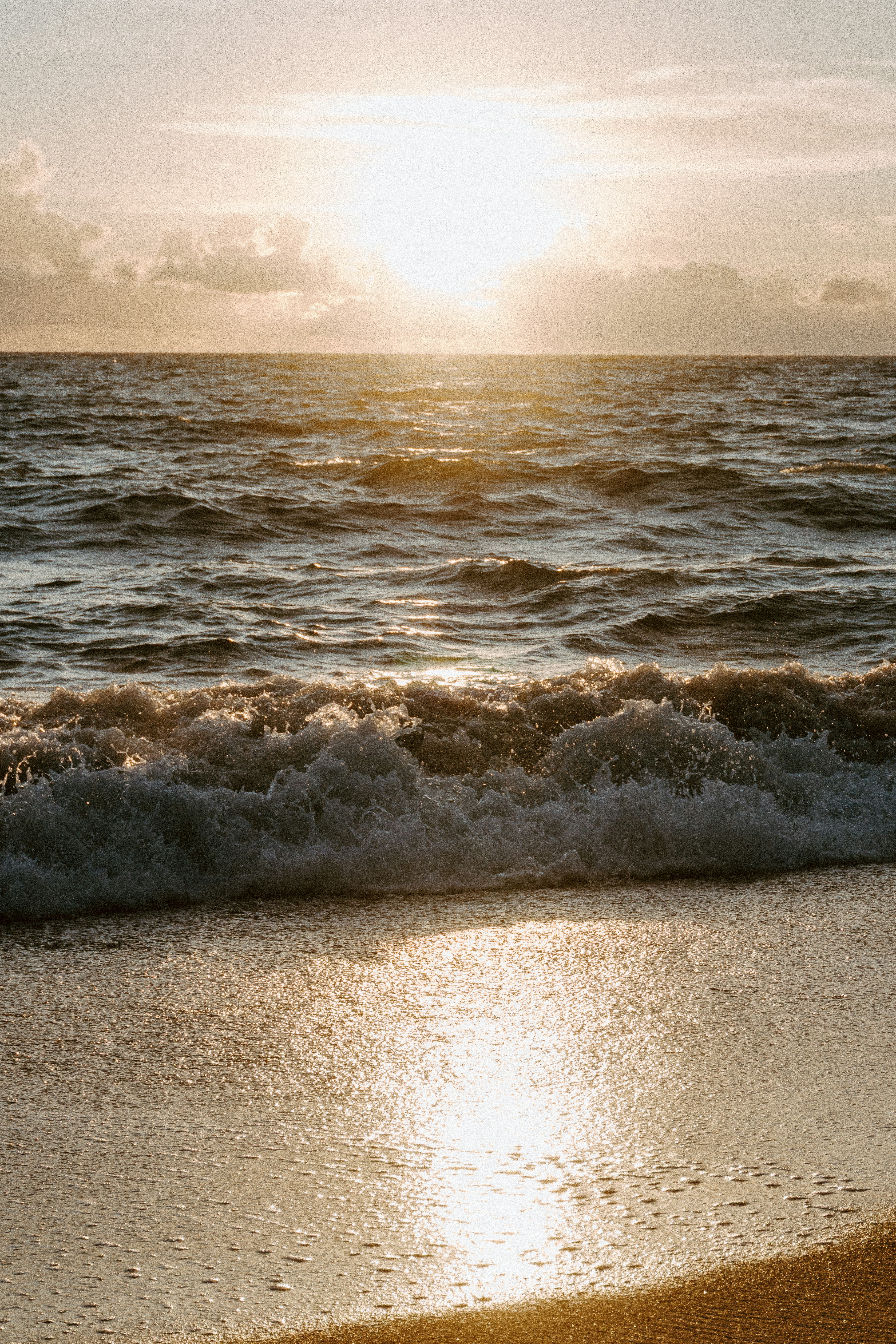 Sunlit Crest: Golden Waves Calming the Shore