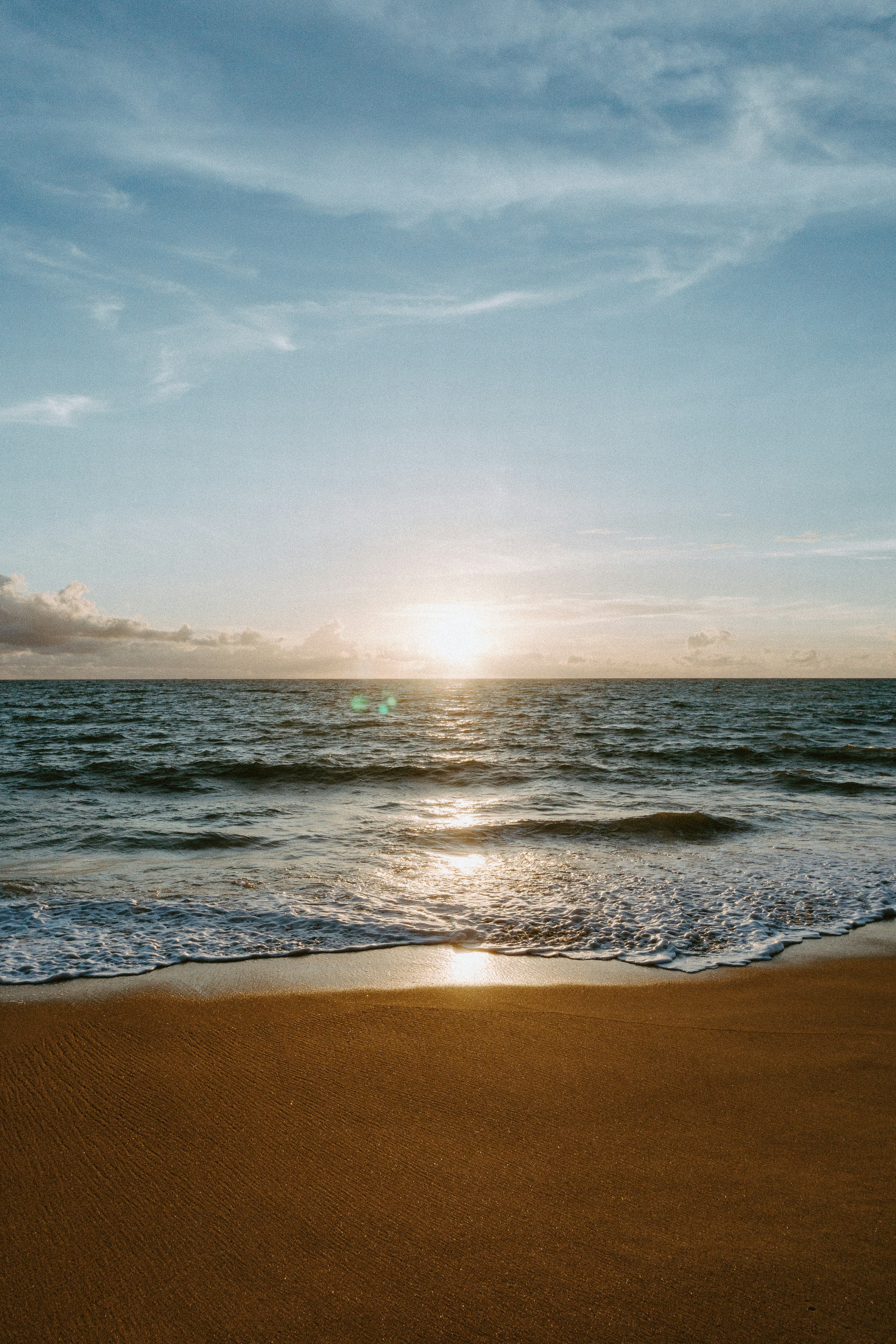 Sunlit Shoreline at Dusk: Horizon Kissed by Waves
