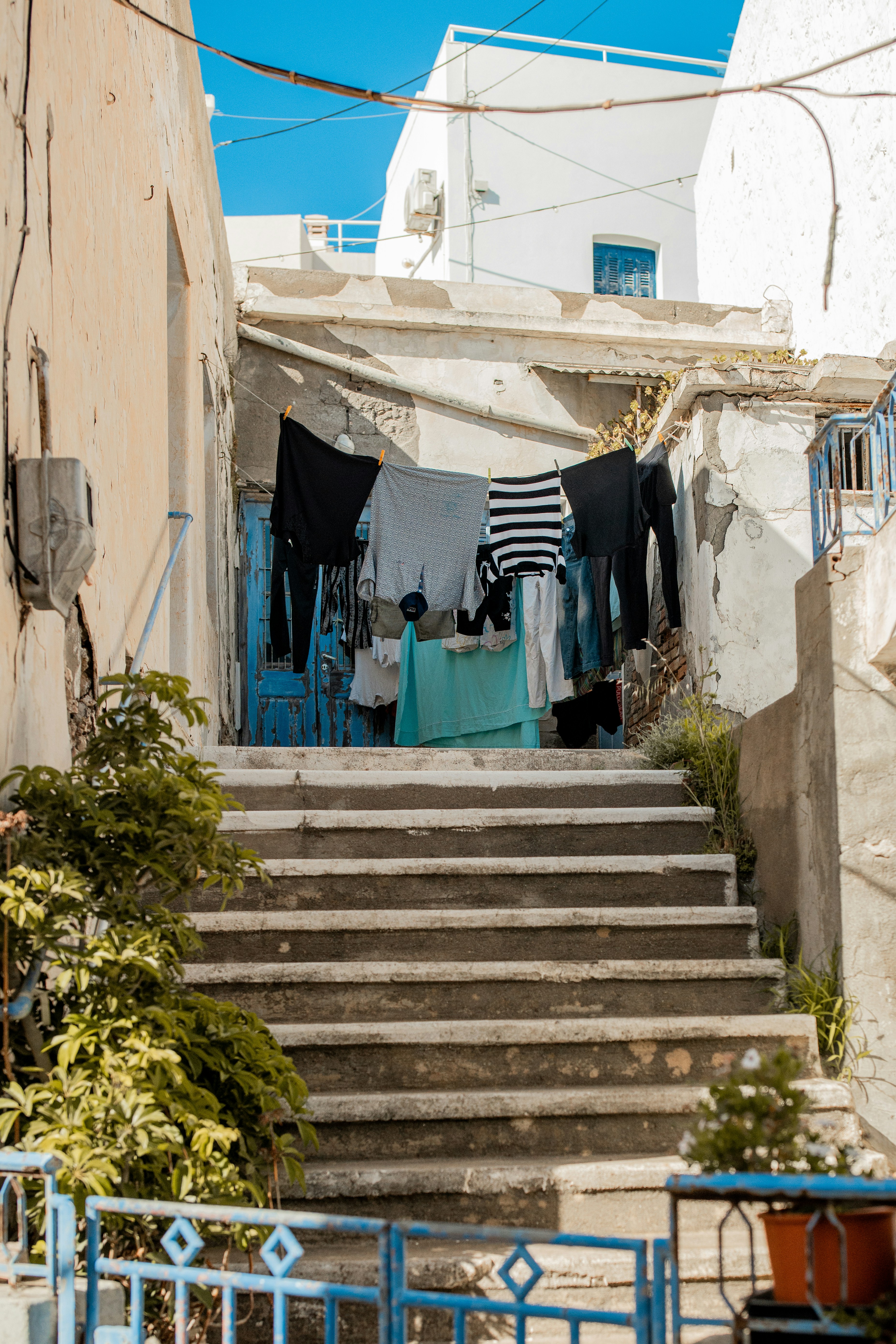 Washing Line Over a Sunlit Concrete Stairway in a Mediterranean Courtyard