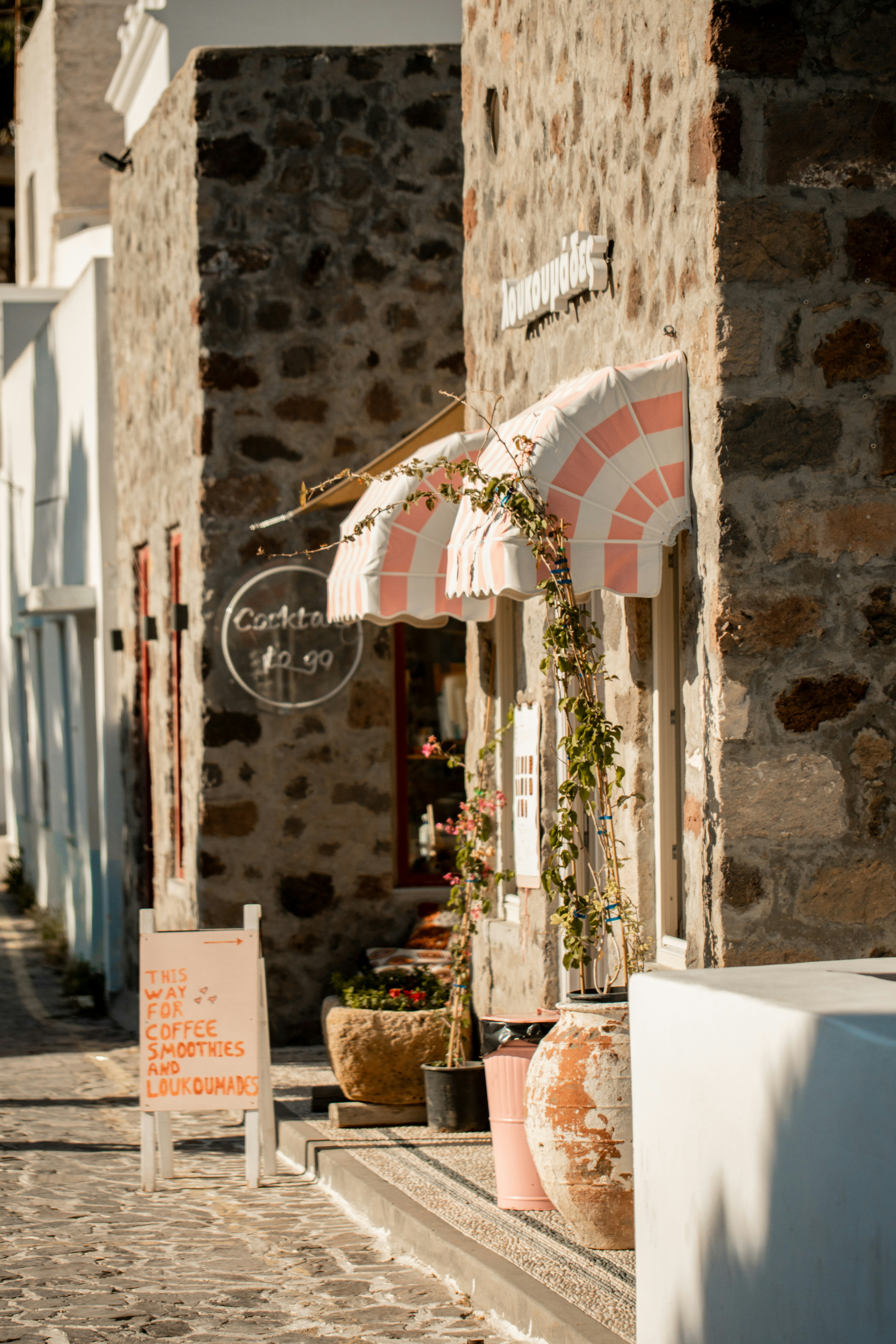 Sunlit stone storefront with striped awning in a sun-warmed alley