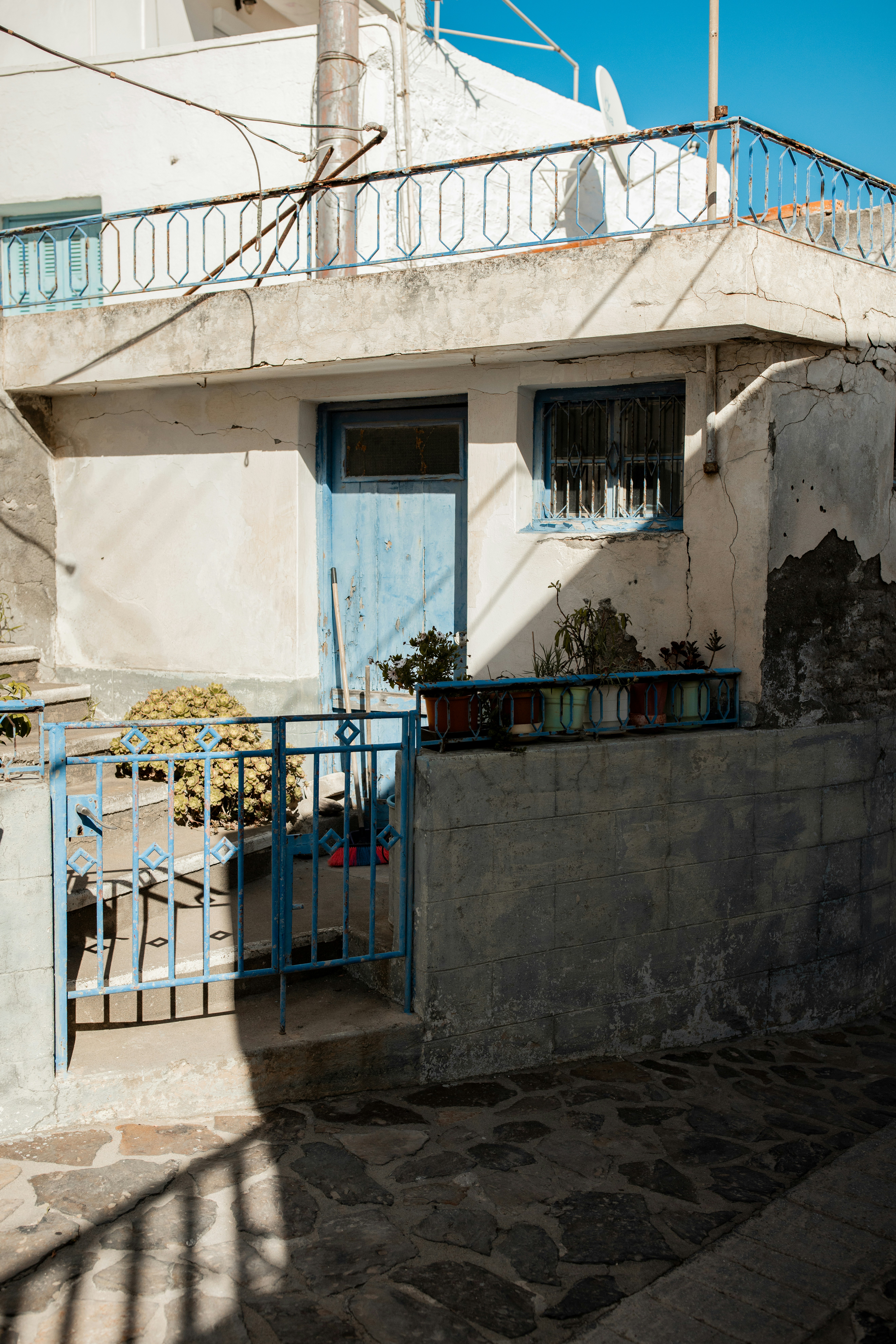 Blue Door, Shadowed Terrace: A Quiet Mediterranean Courtyard
