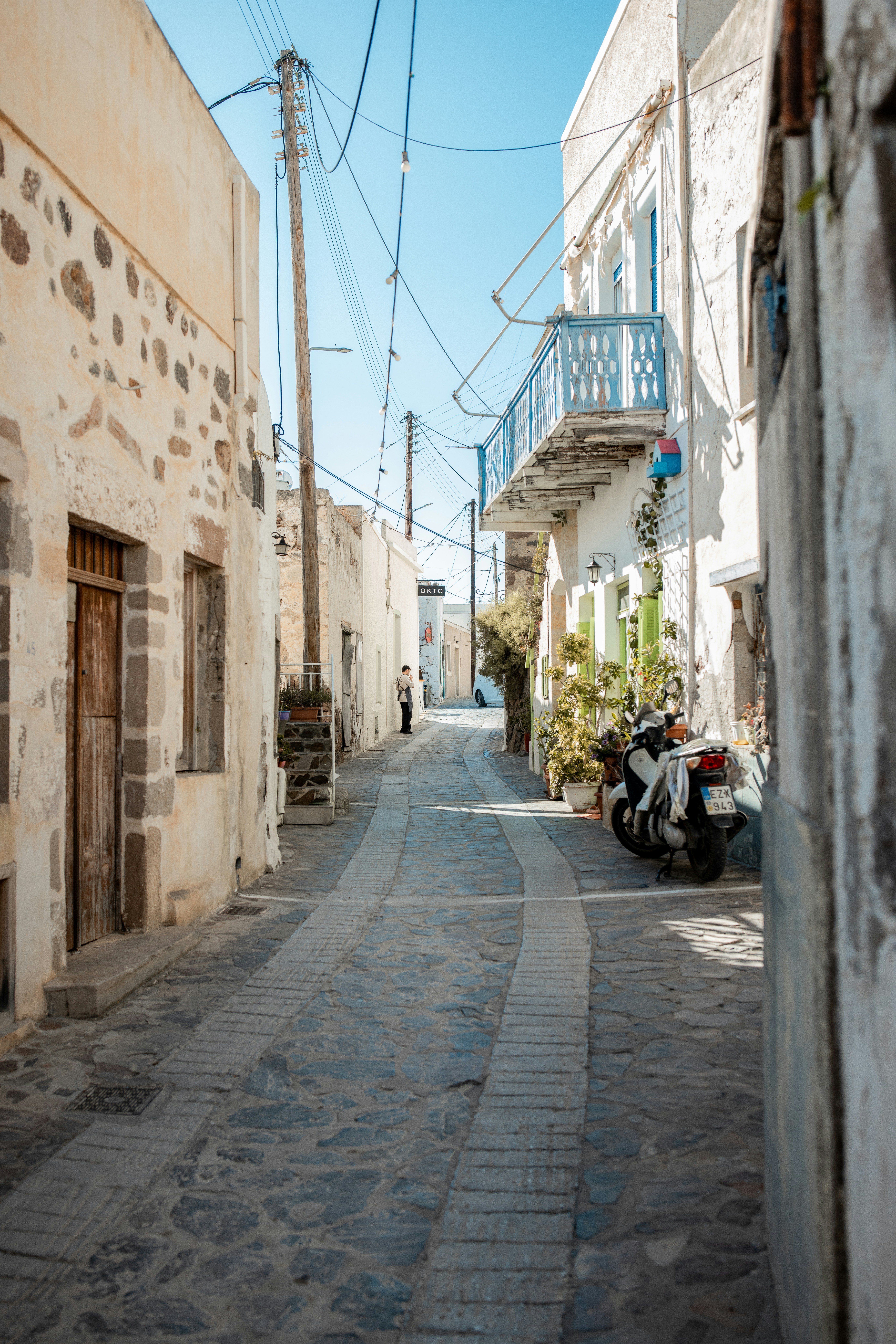 Cobbled street vanishing toward a sunlit arcade