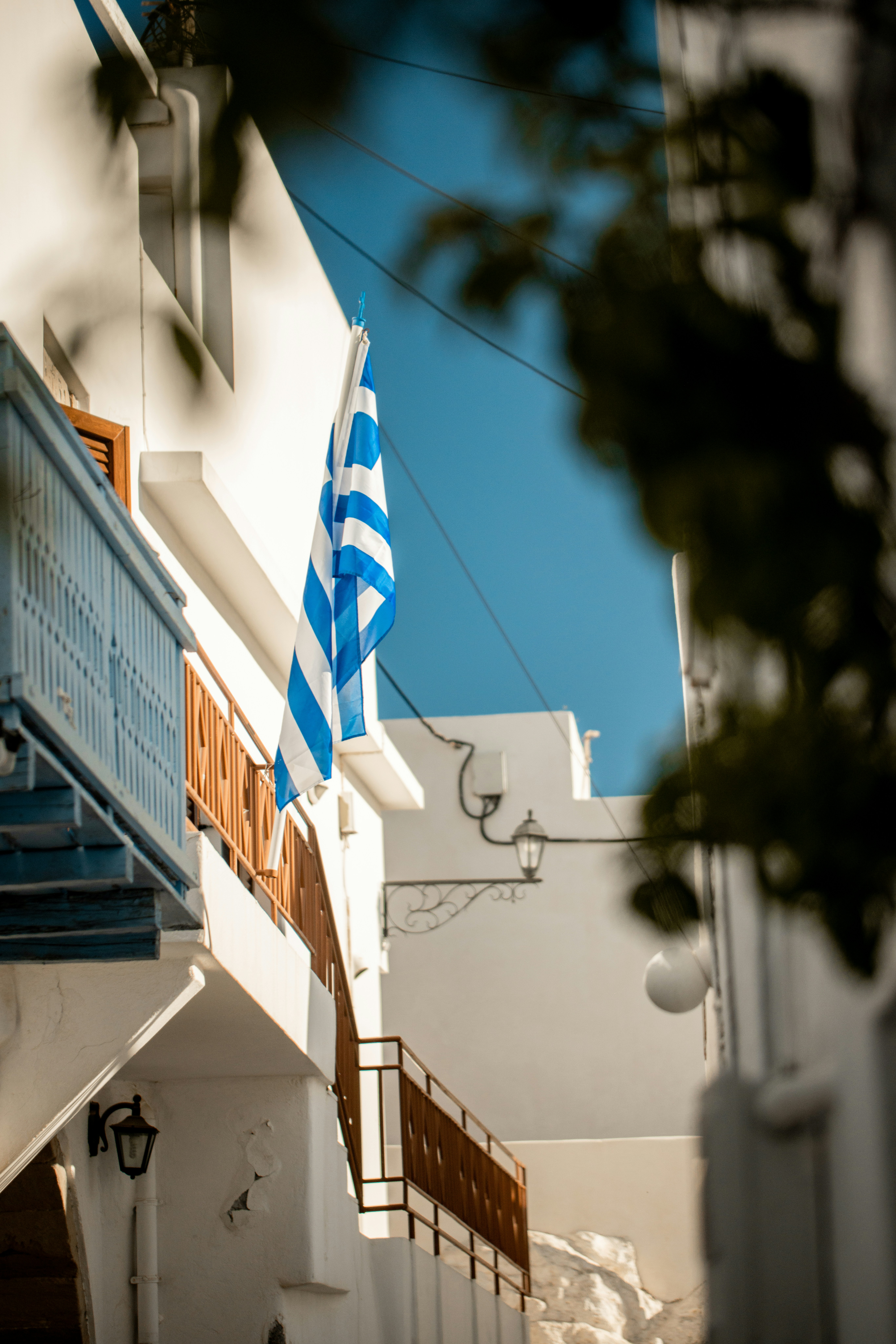 Blue Flag, White Facades: A Mediterranean Balcony in Sunlit Quiet