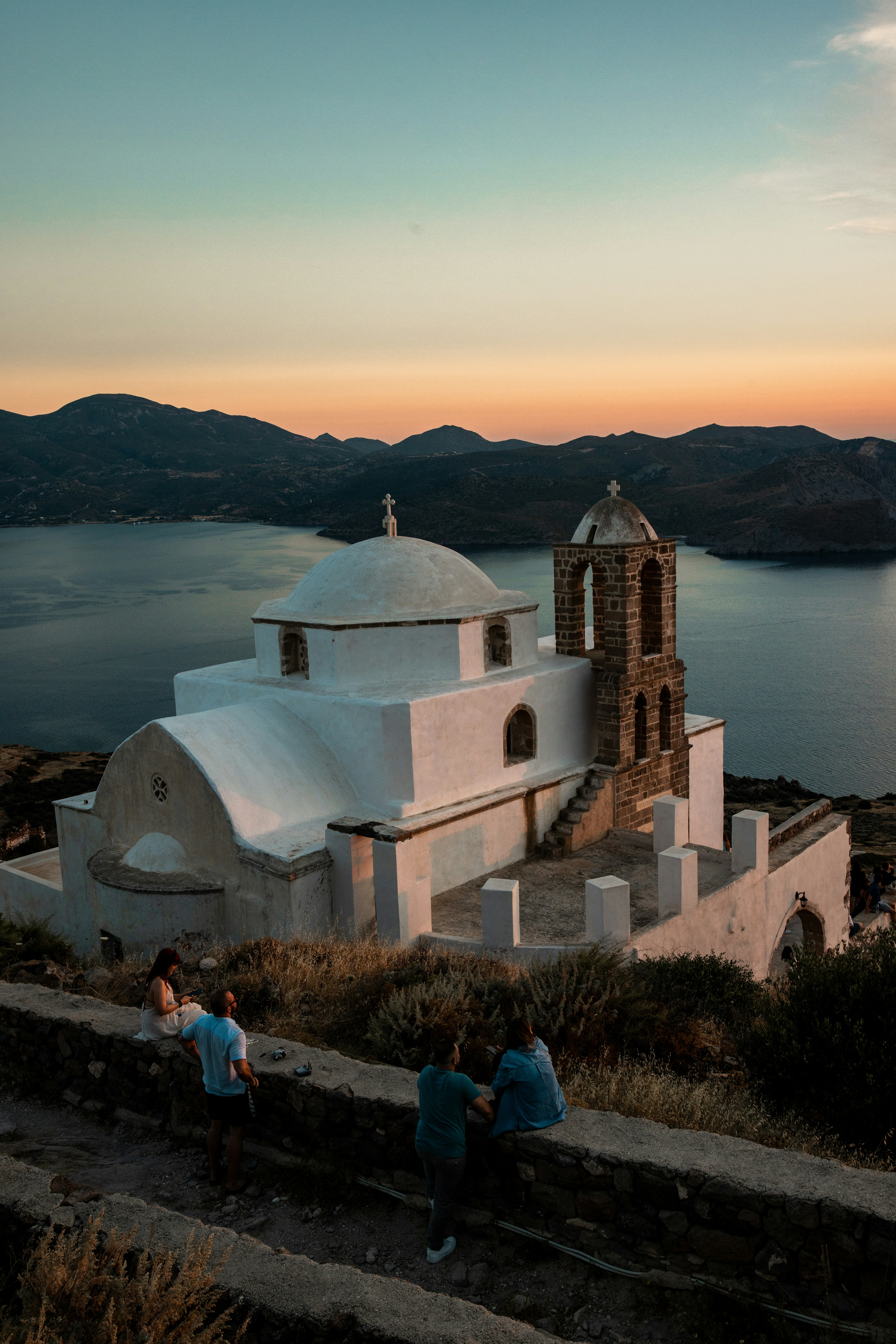 Sunset at a peaceful Cycladic chapel perched above the sea
