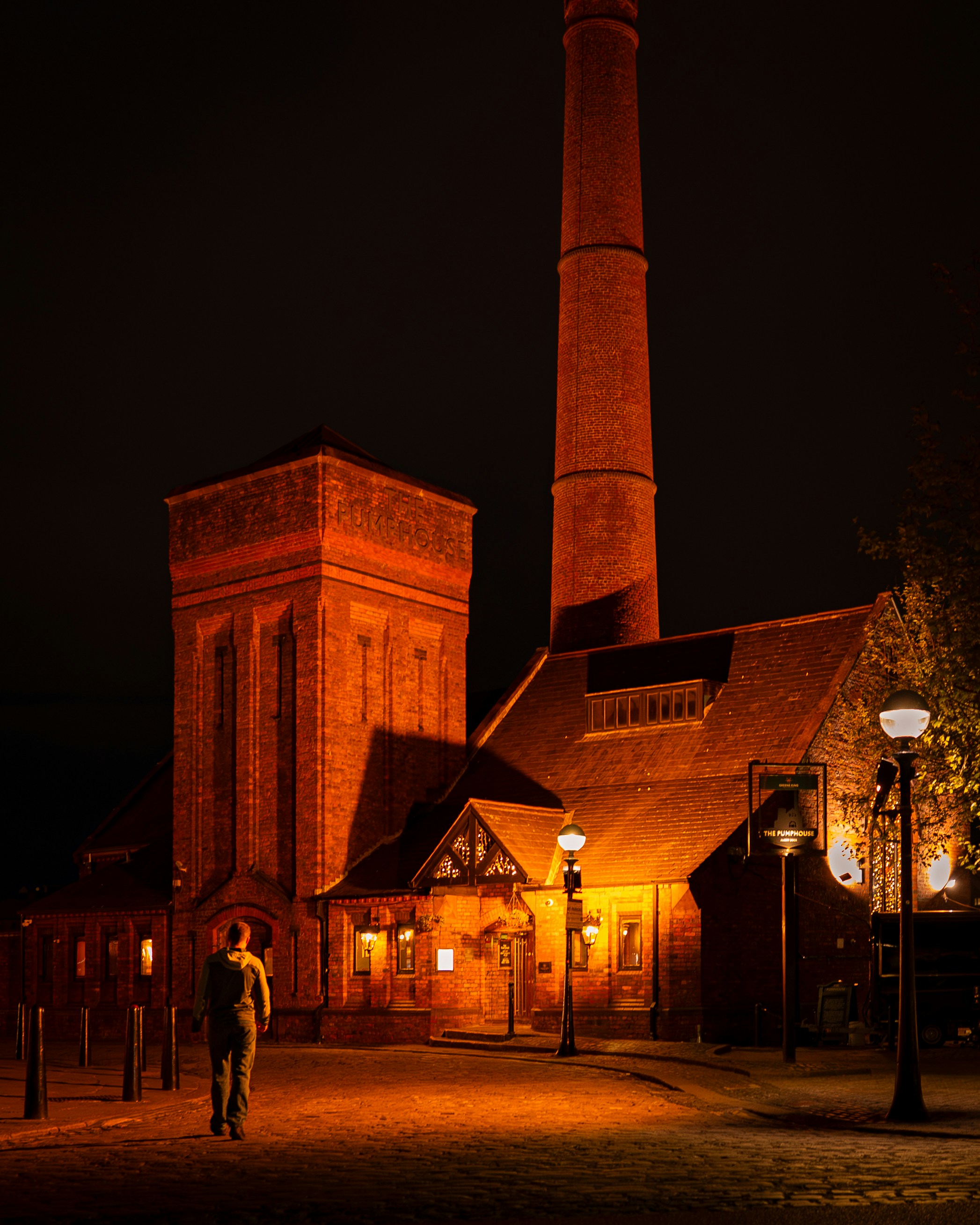 Night at the Brick Works: A Lone Figure Under the Warm Loom of Industrial Light
