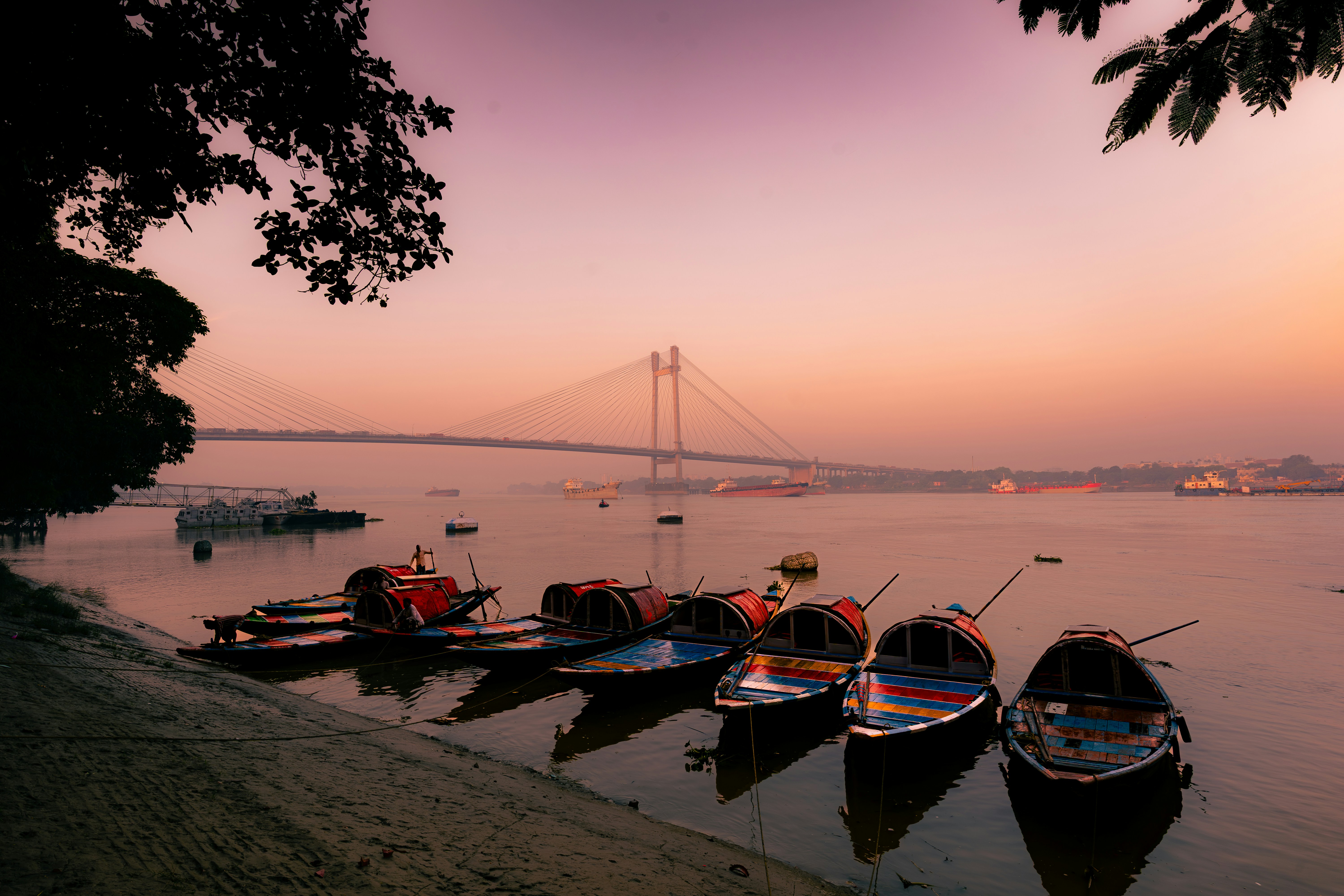 Rammed Boats at Dusk: A Calm River with a Silhouette of a Suspension Bridge