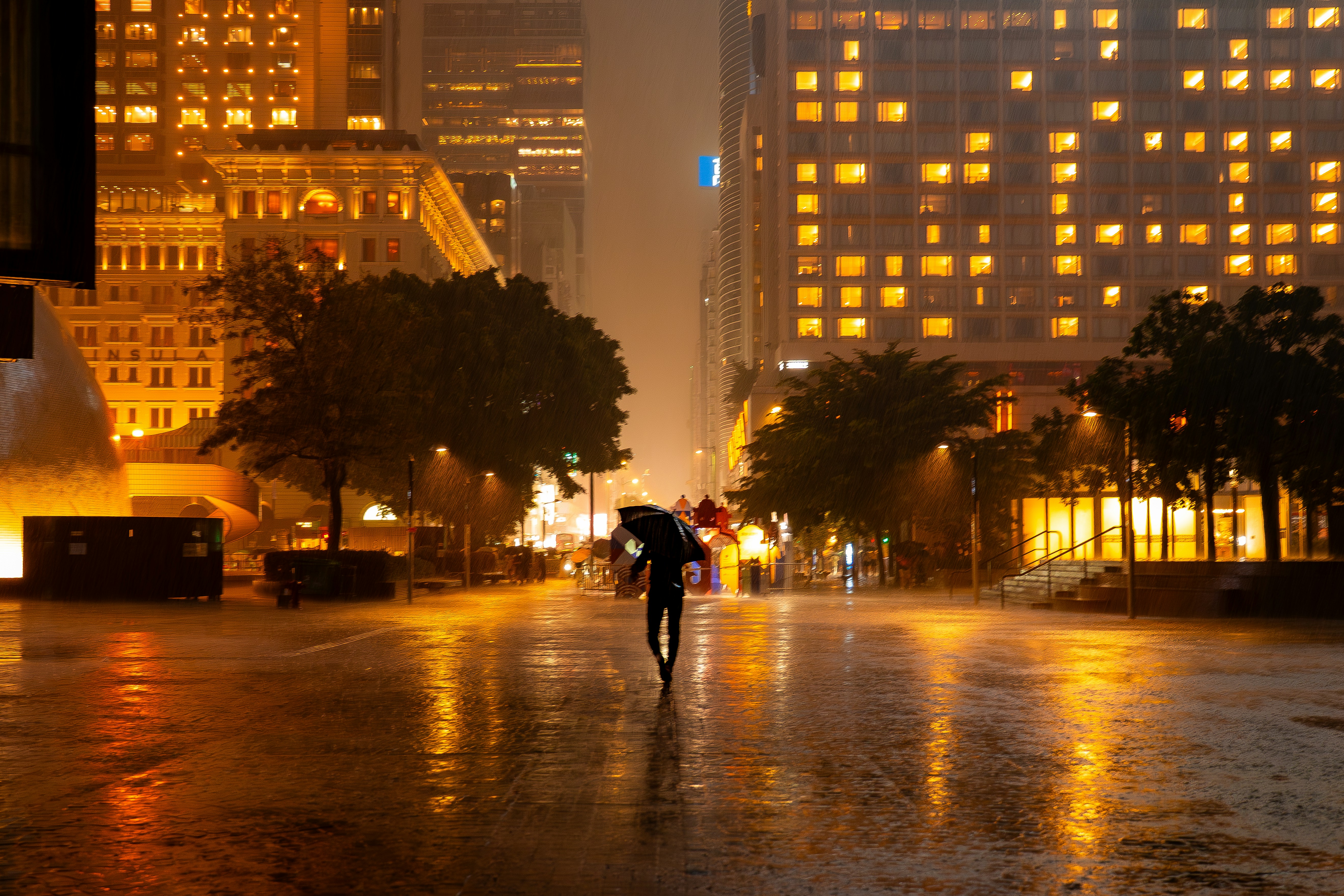 Neon Rain: A Lone Figure Briskly Walks Beneath City Lights