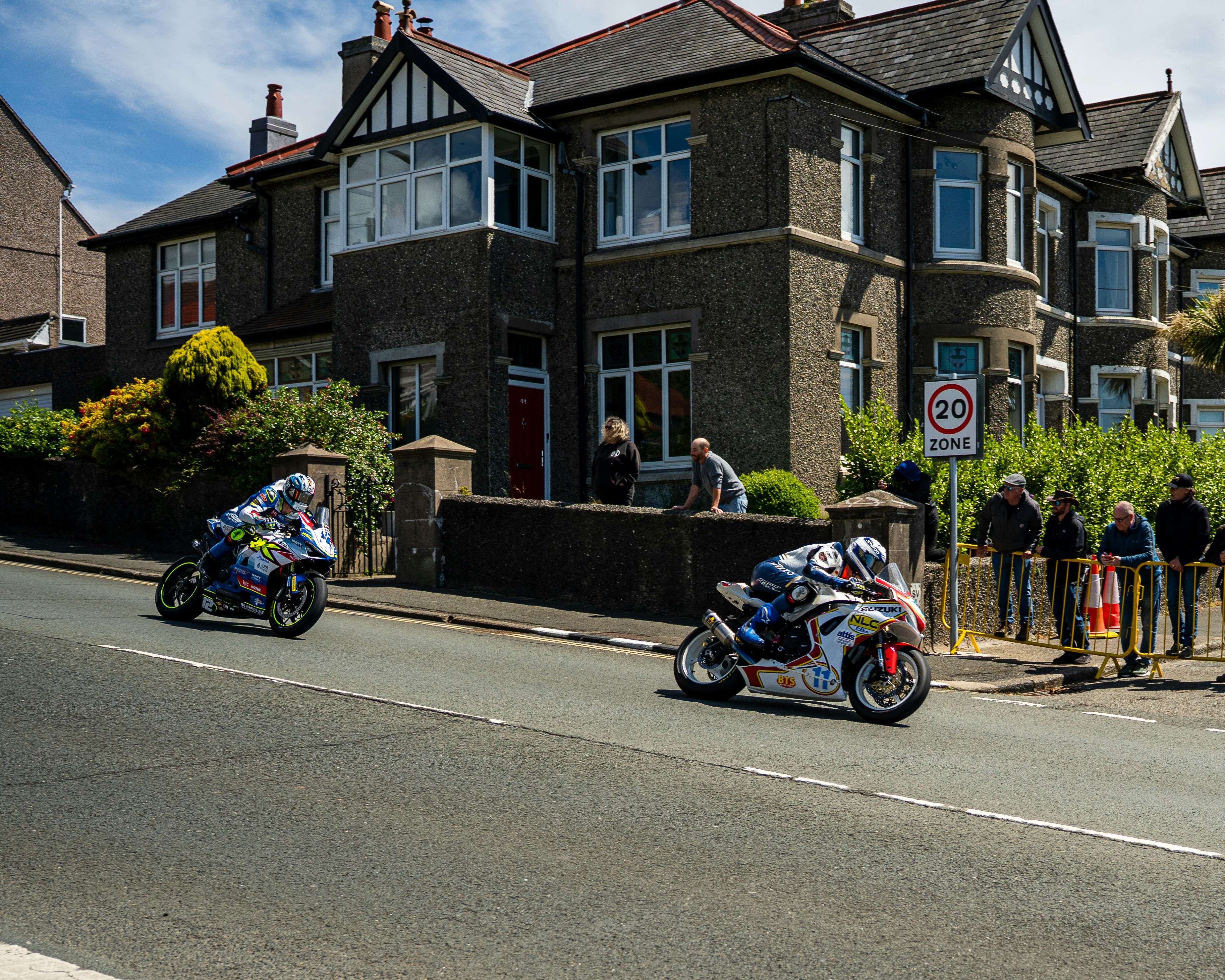 Two Racing Motorbikes Blaze Past a Quiet Street