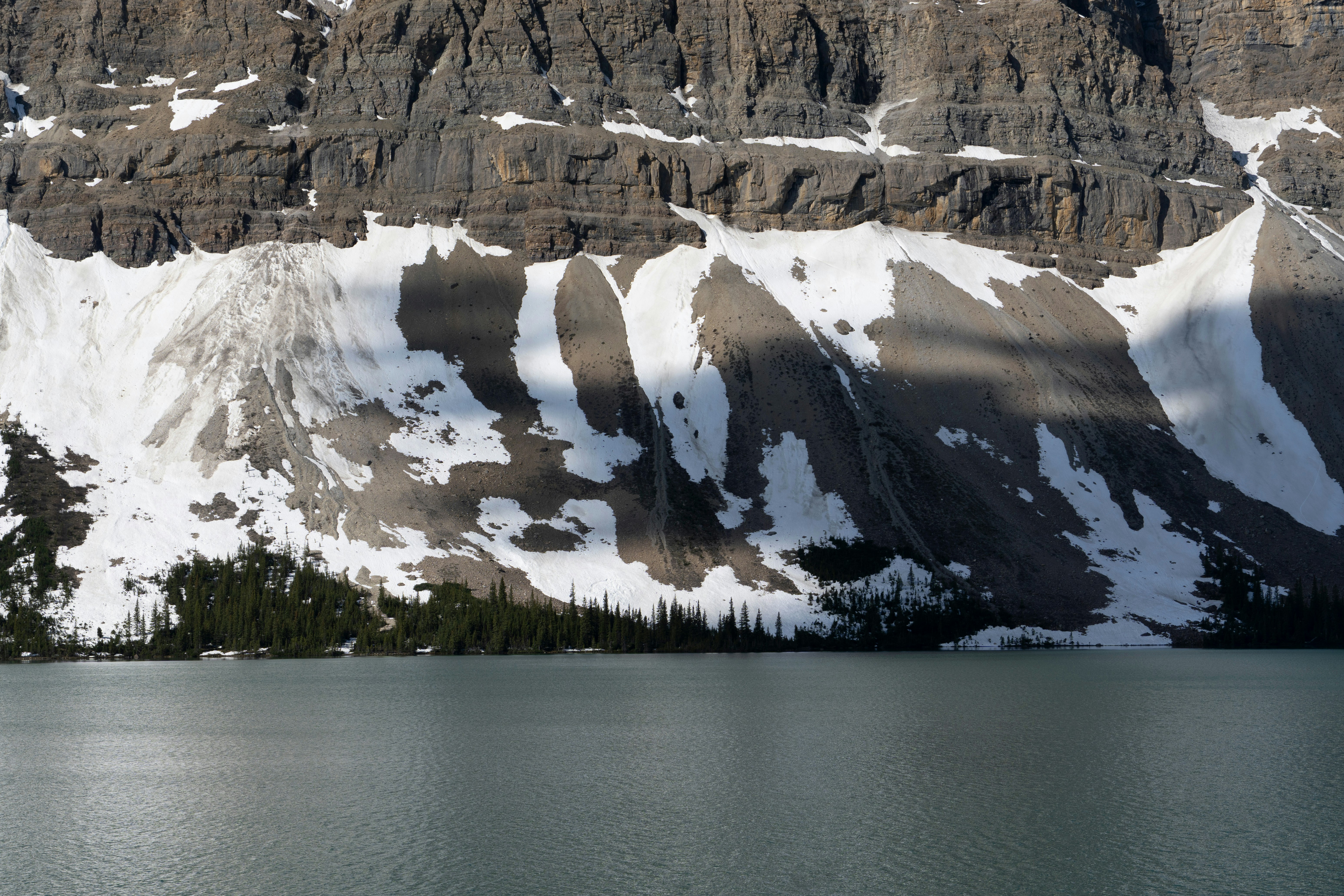 Glacial Fjord Backdrop: Snow-veiled Cliff Meet Calm Water