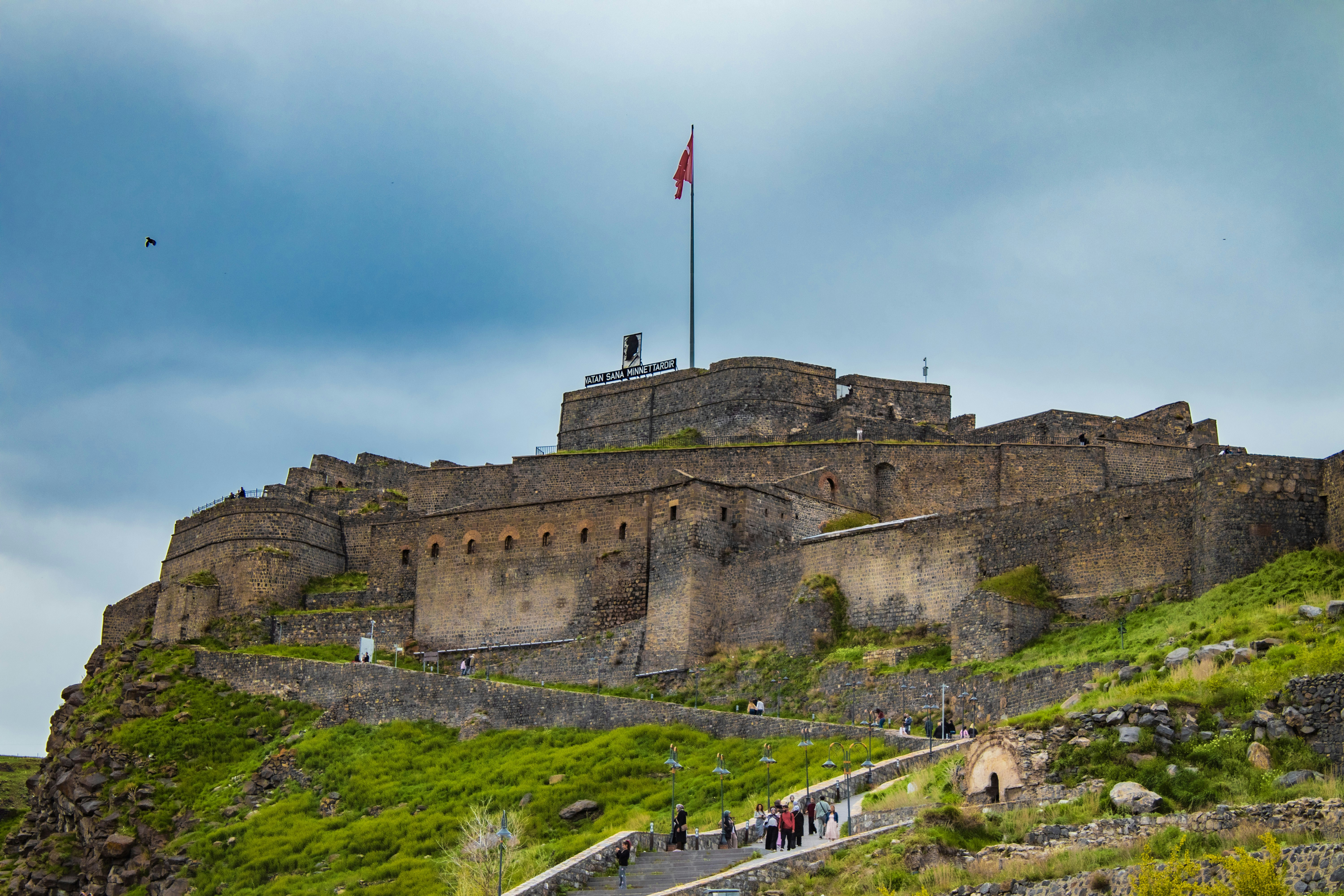 Flag over the Fortress: Path of Visitors Ascends the Hill