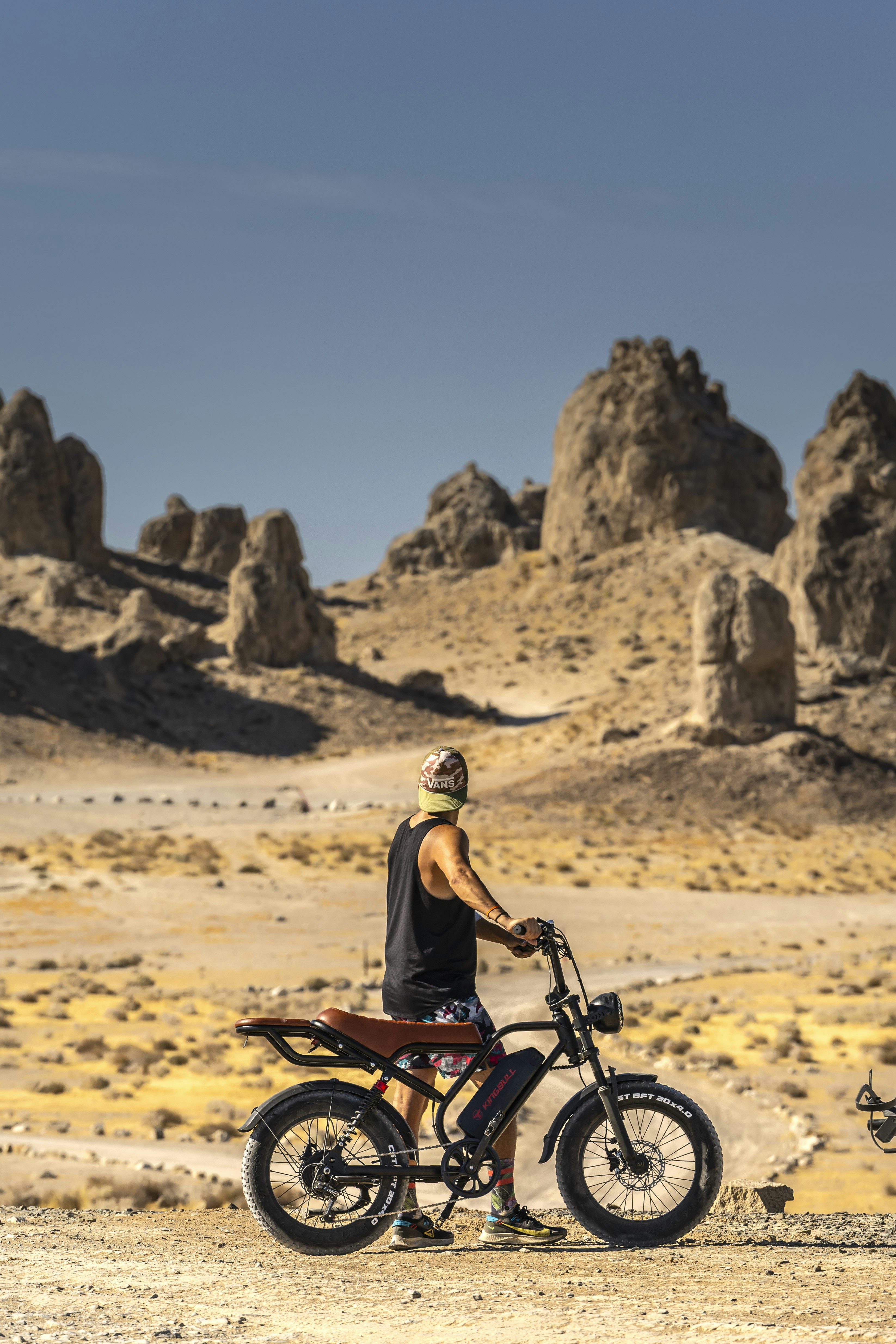 Desert Rider: A lone motorcyclist pauses amid sculpted stone monoliths under a vast blue sky