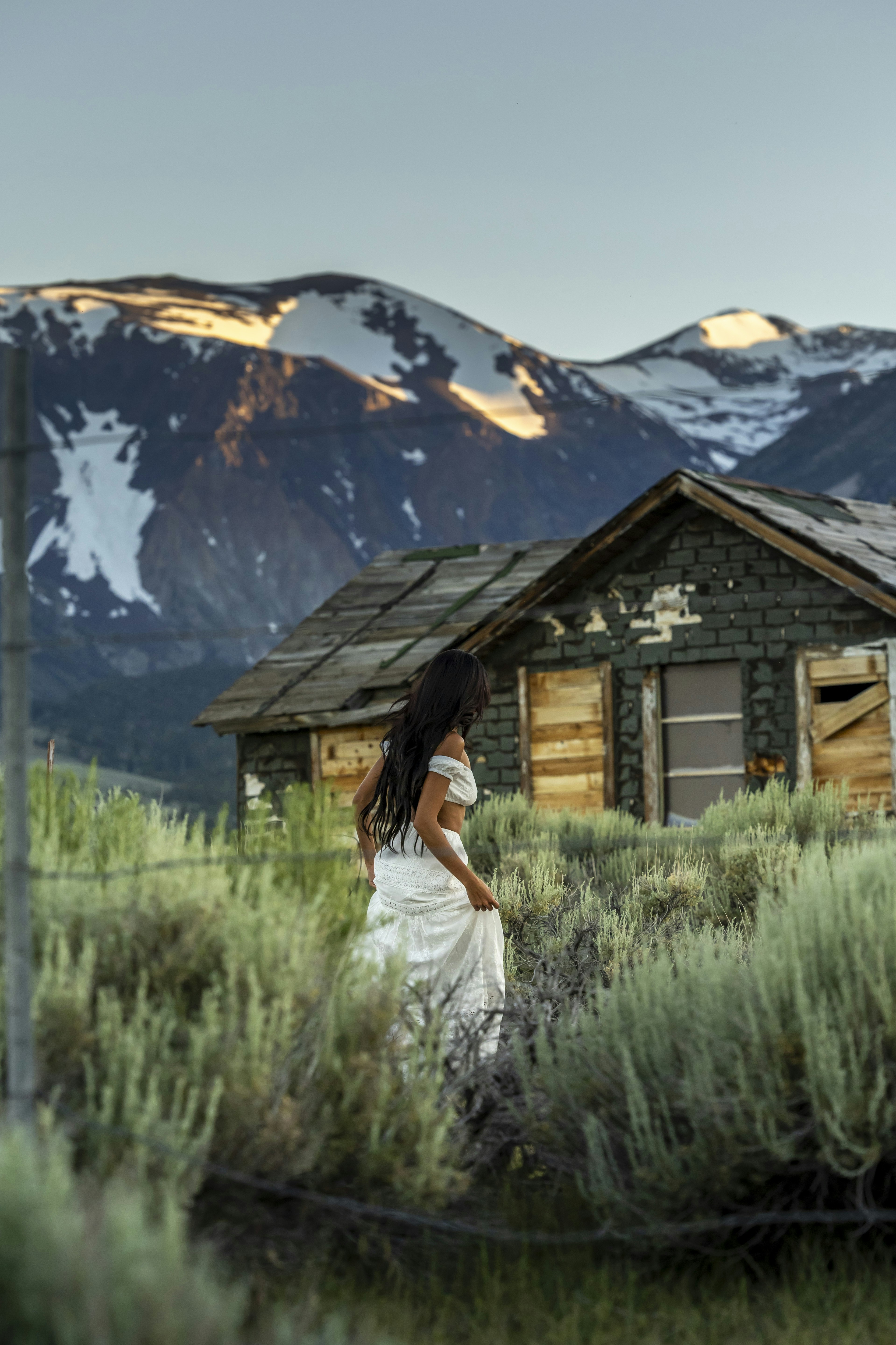 White Dress in a Sage Brush Meadow Before Snowy Peaks