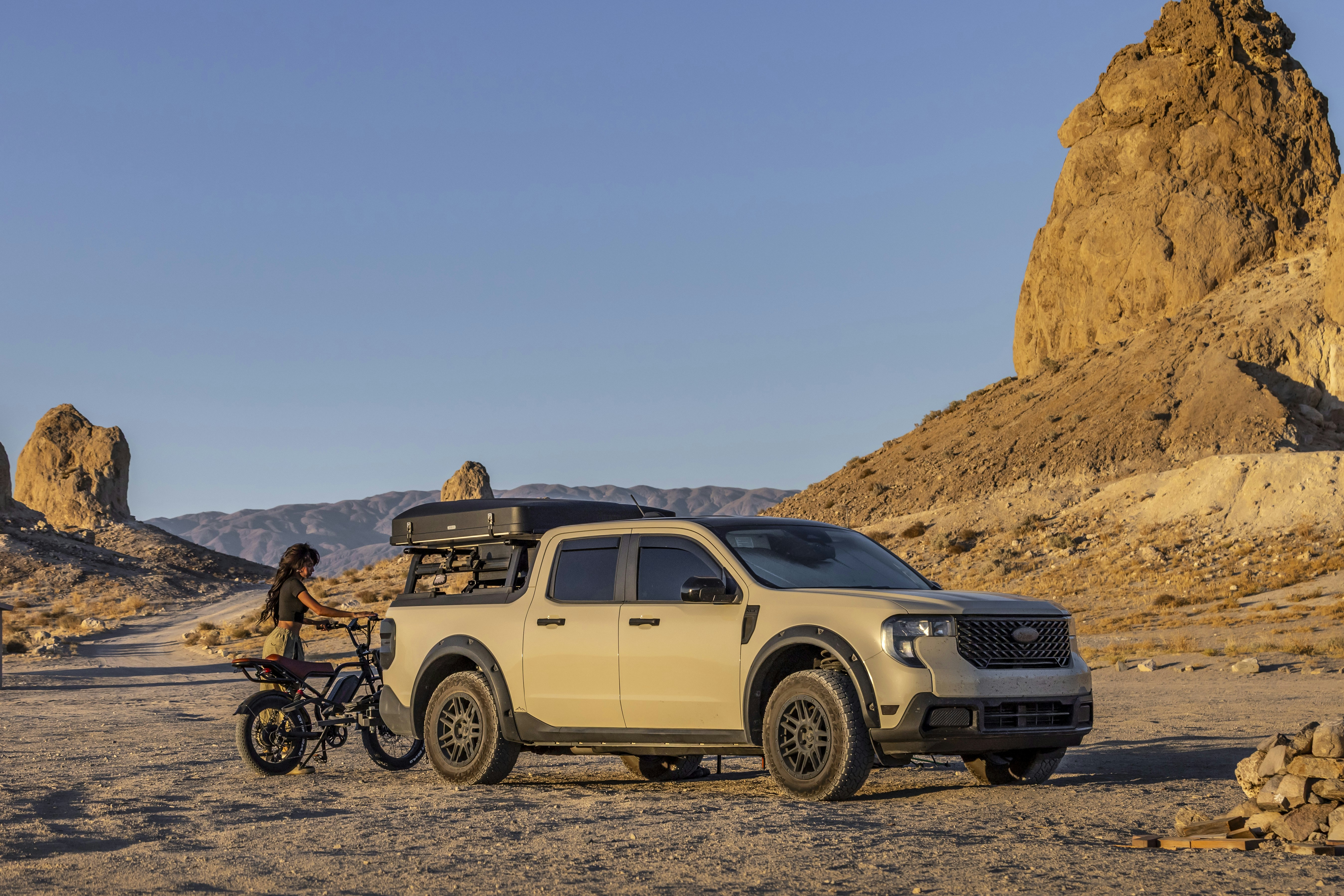 Desert Drive: A Pickup and a Rider amid Weathered Rocks at Dusk
