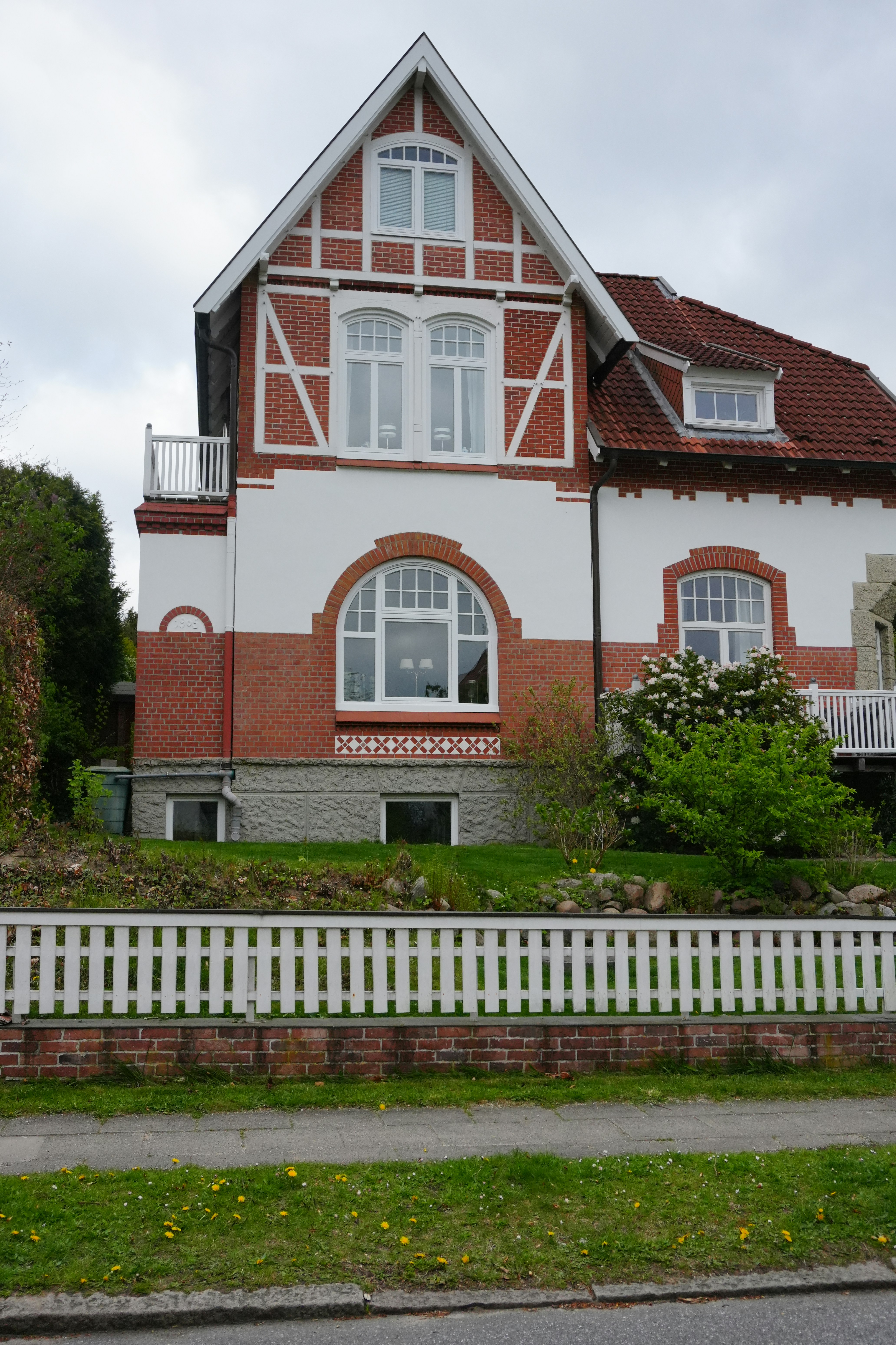Brick-and-White Villa with Gabled Summit and Lush Garden