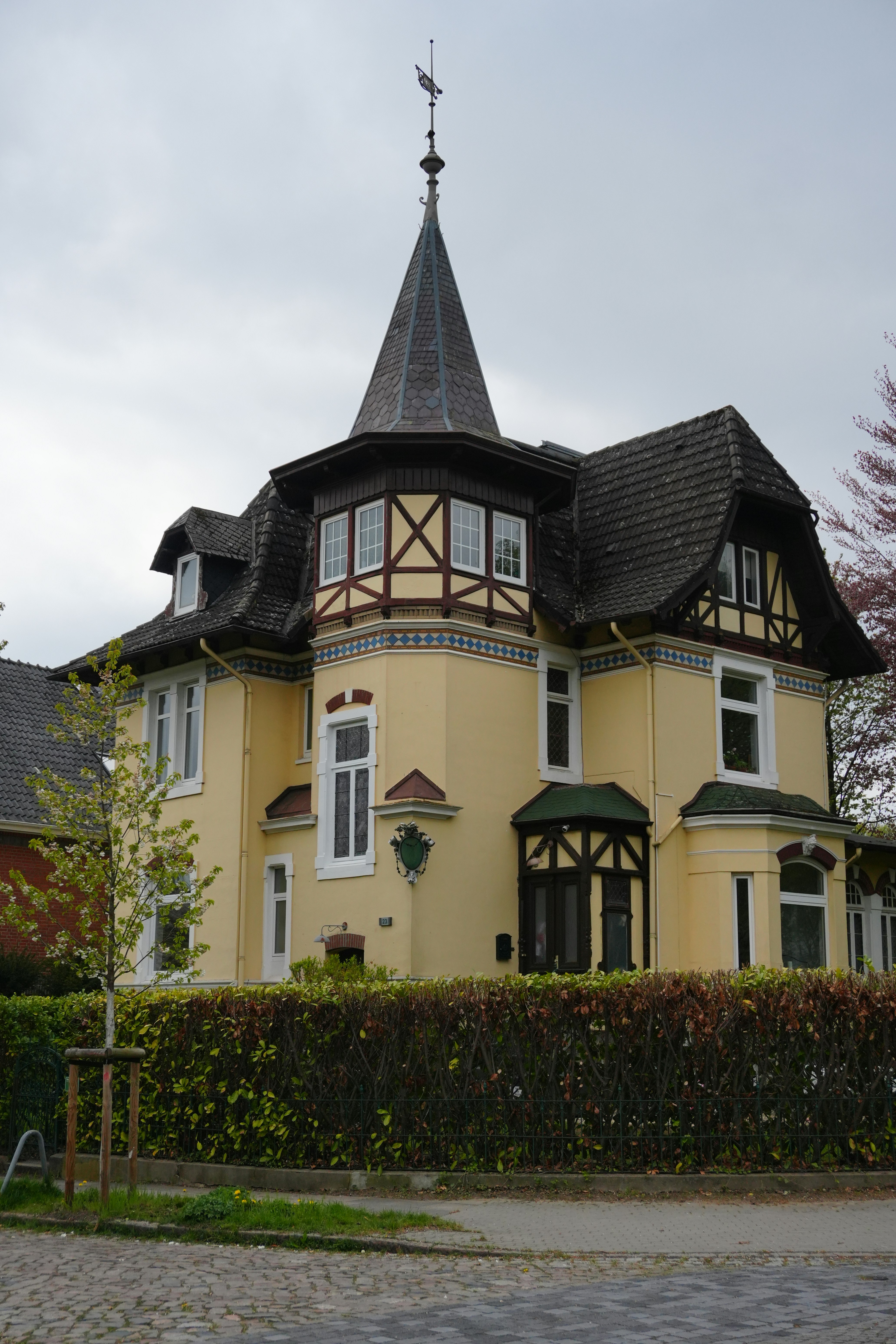 Yellow Facade Manor with Decorative Timber Detailing Under a Steep Turret