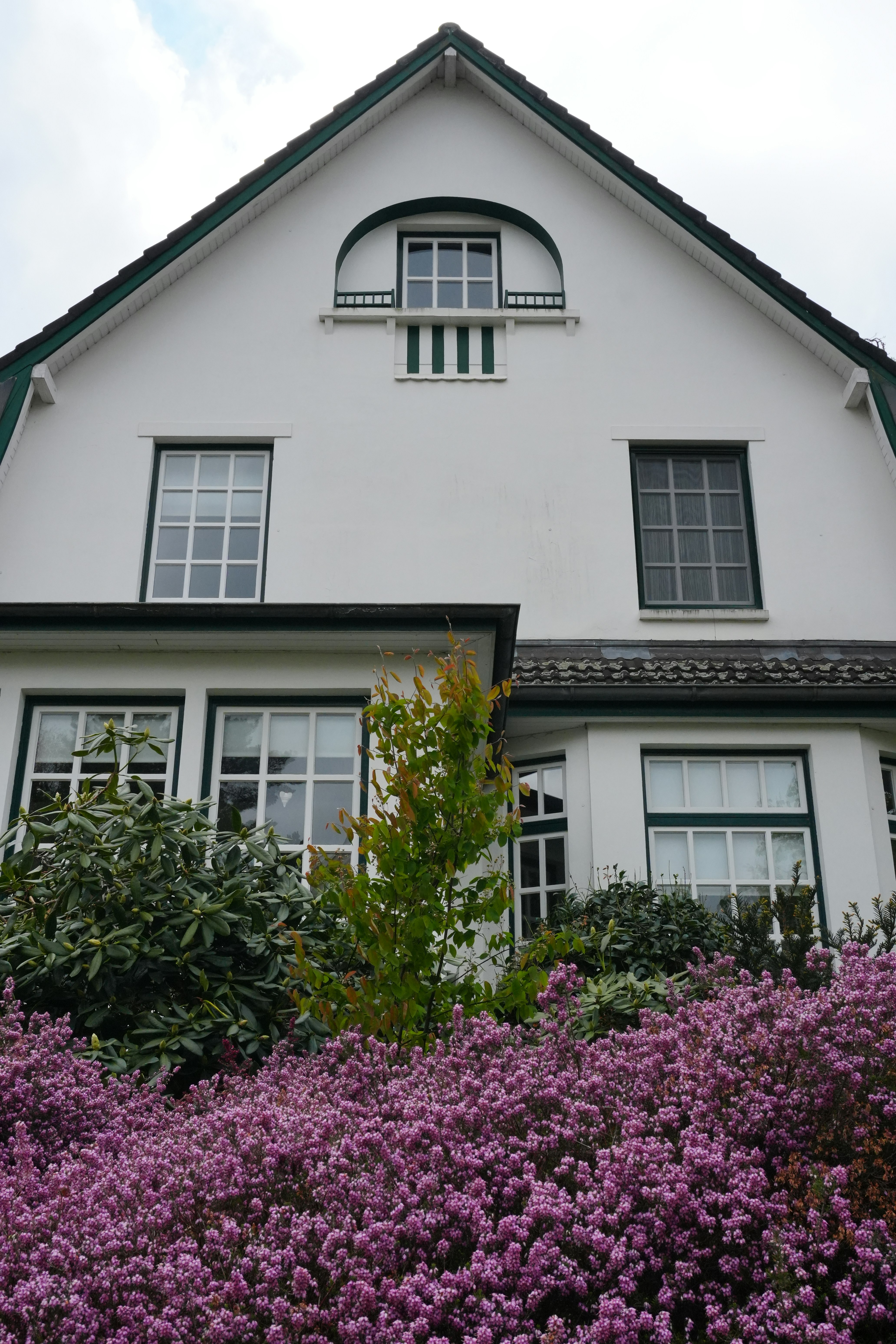 White-Faced Villa Beneath a Violet Bloom Border