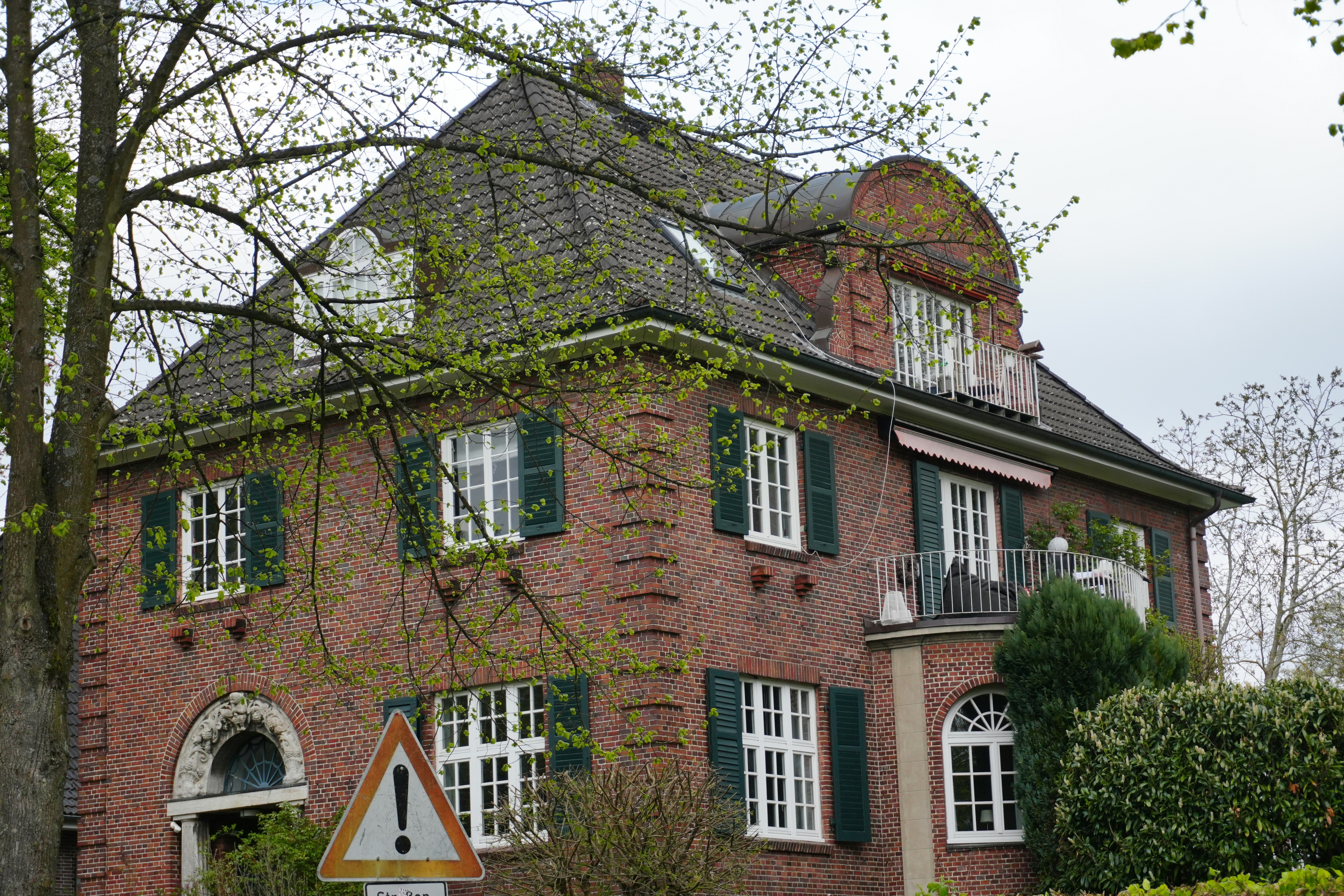 Brick Villa Amid Spring Verdure with Curb Signage