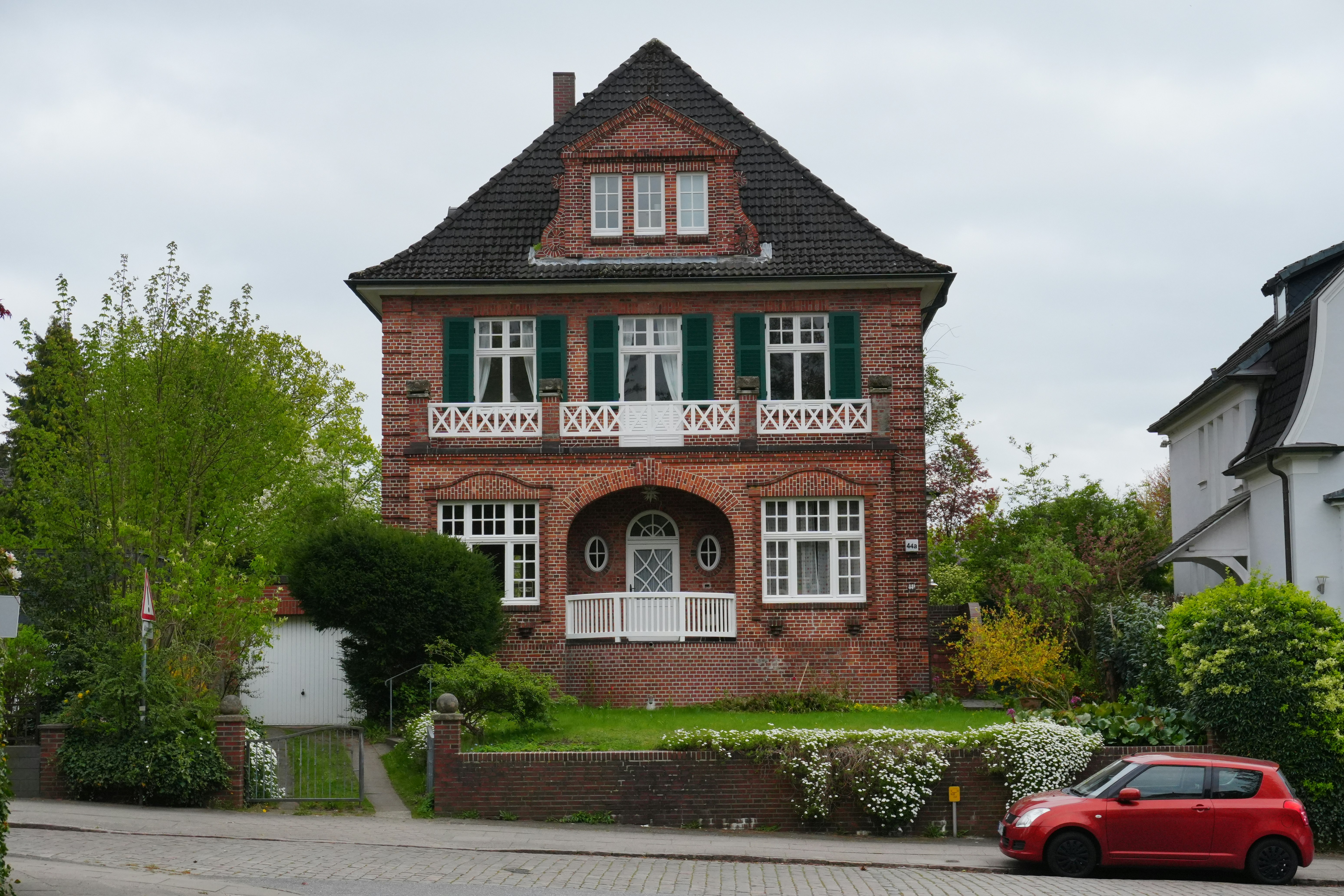 Brick Villa with Green Shutters Across a Quiet Street
