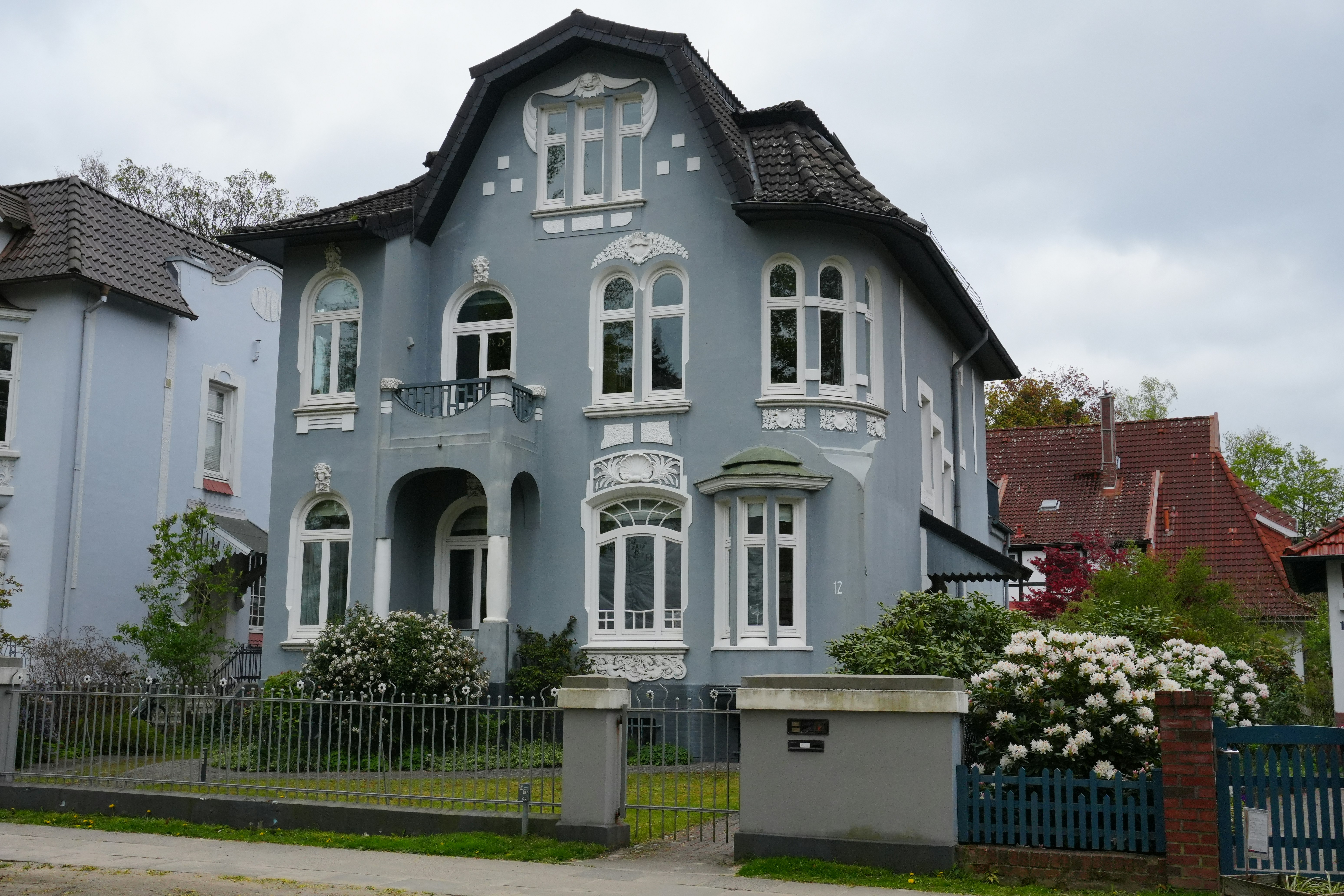 Blue Victorian Villa with Ornate White Trim and Garden Fence