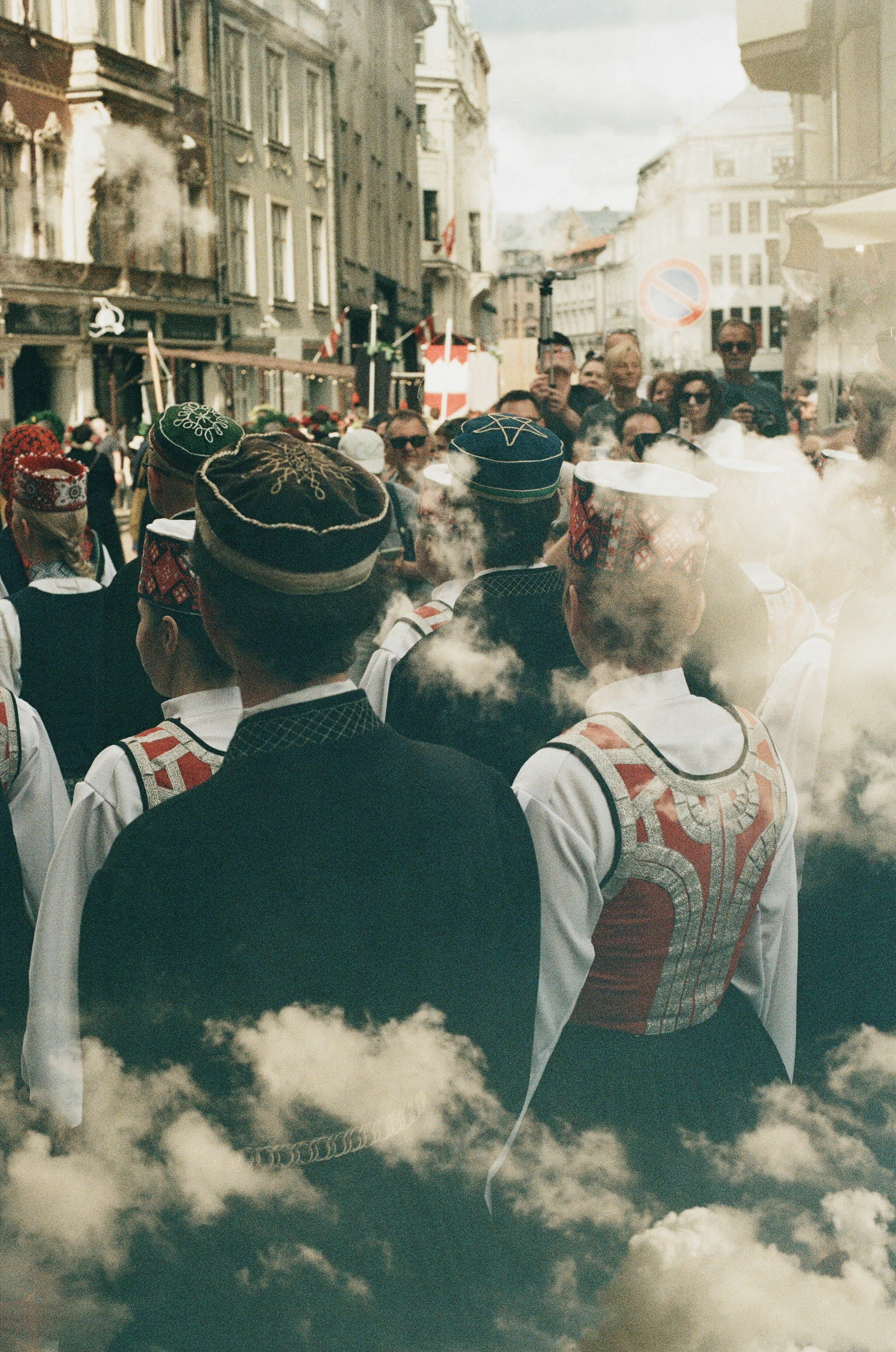 Marching in Steam and Color: Traditional Attire Amid Urban Fog