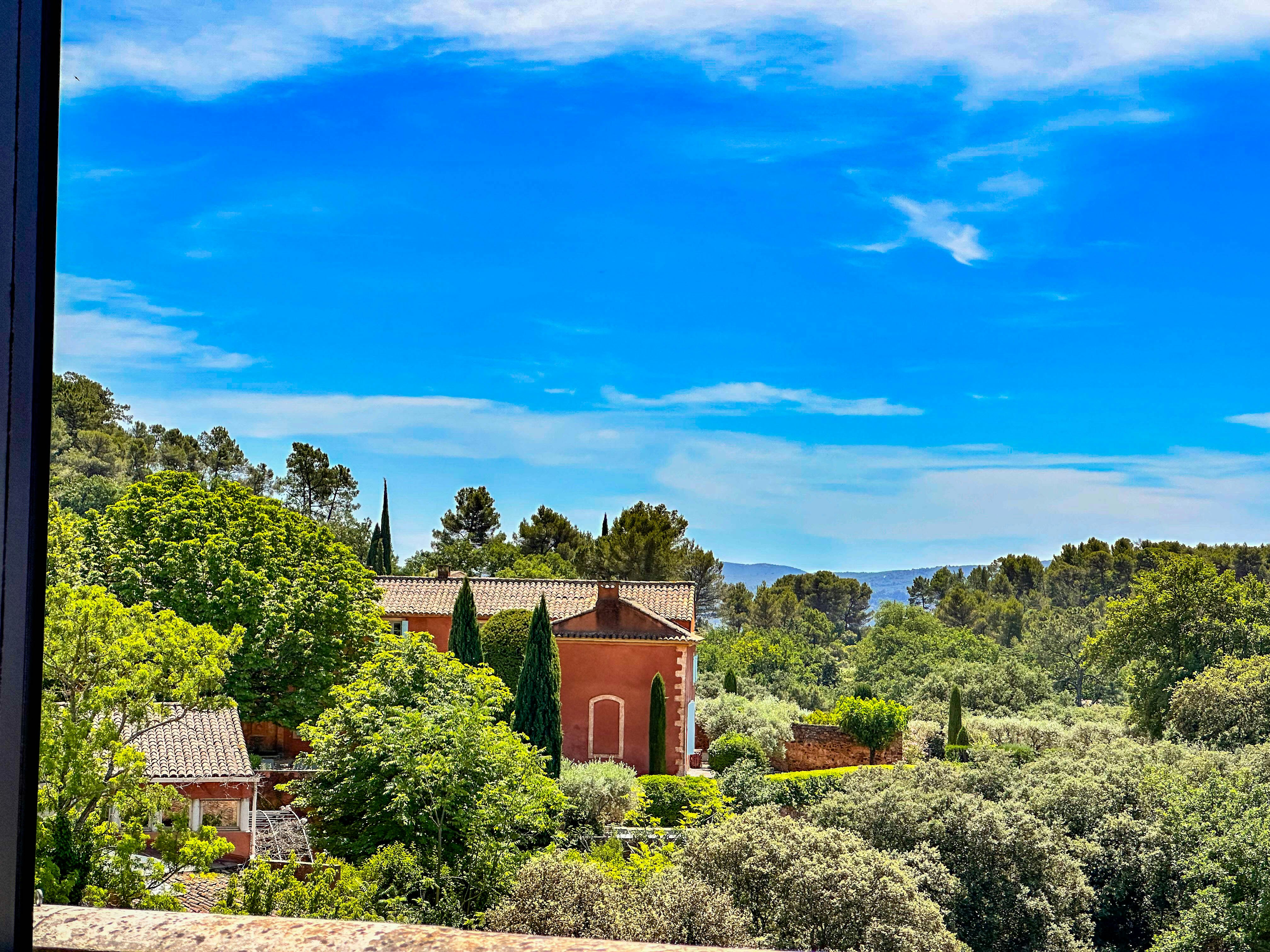 Sunlit villa among olive groves under a vivid sky