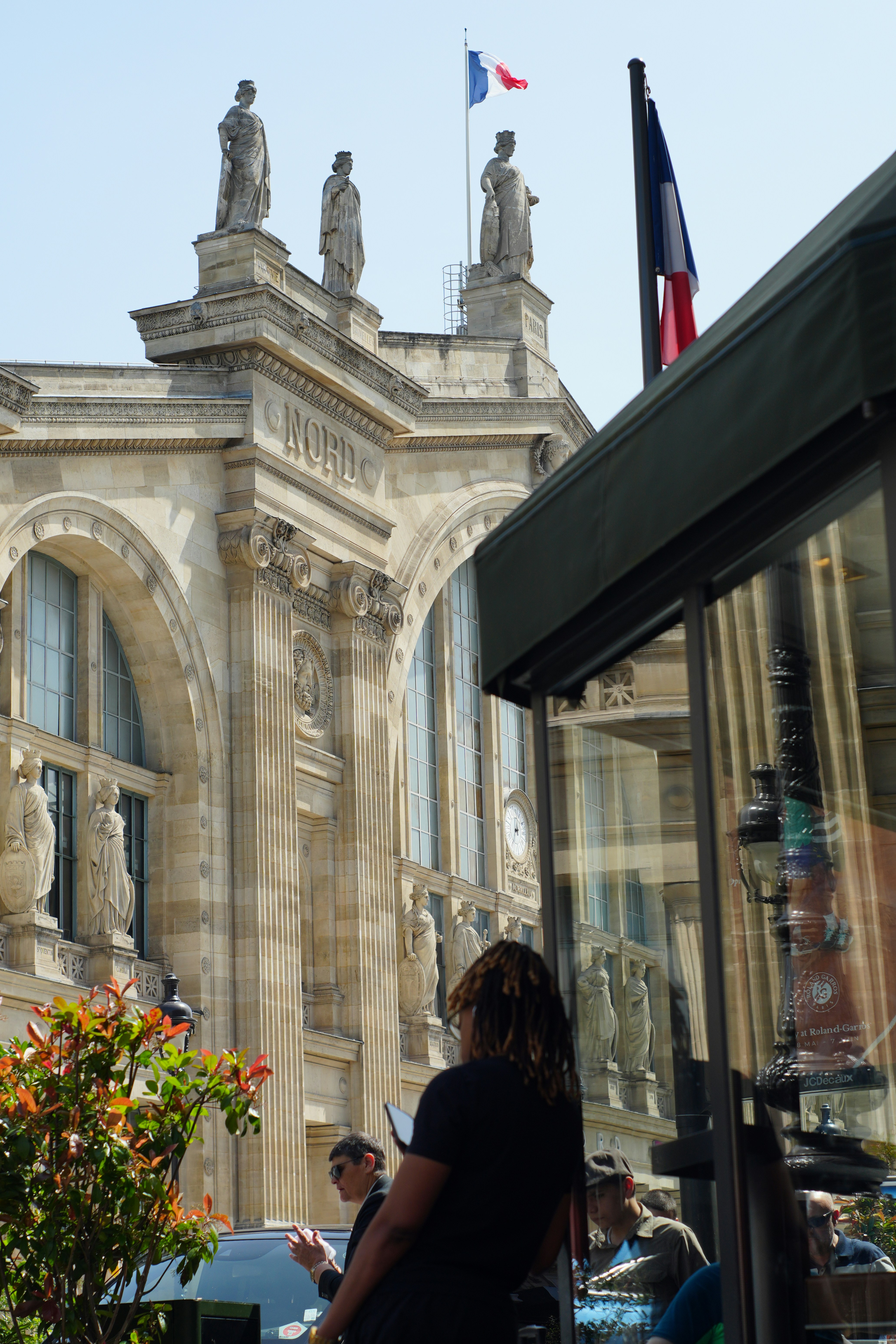 Statues and Parisian Facade Framed by Modern Glass