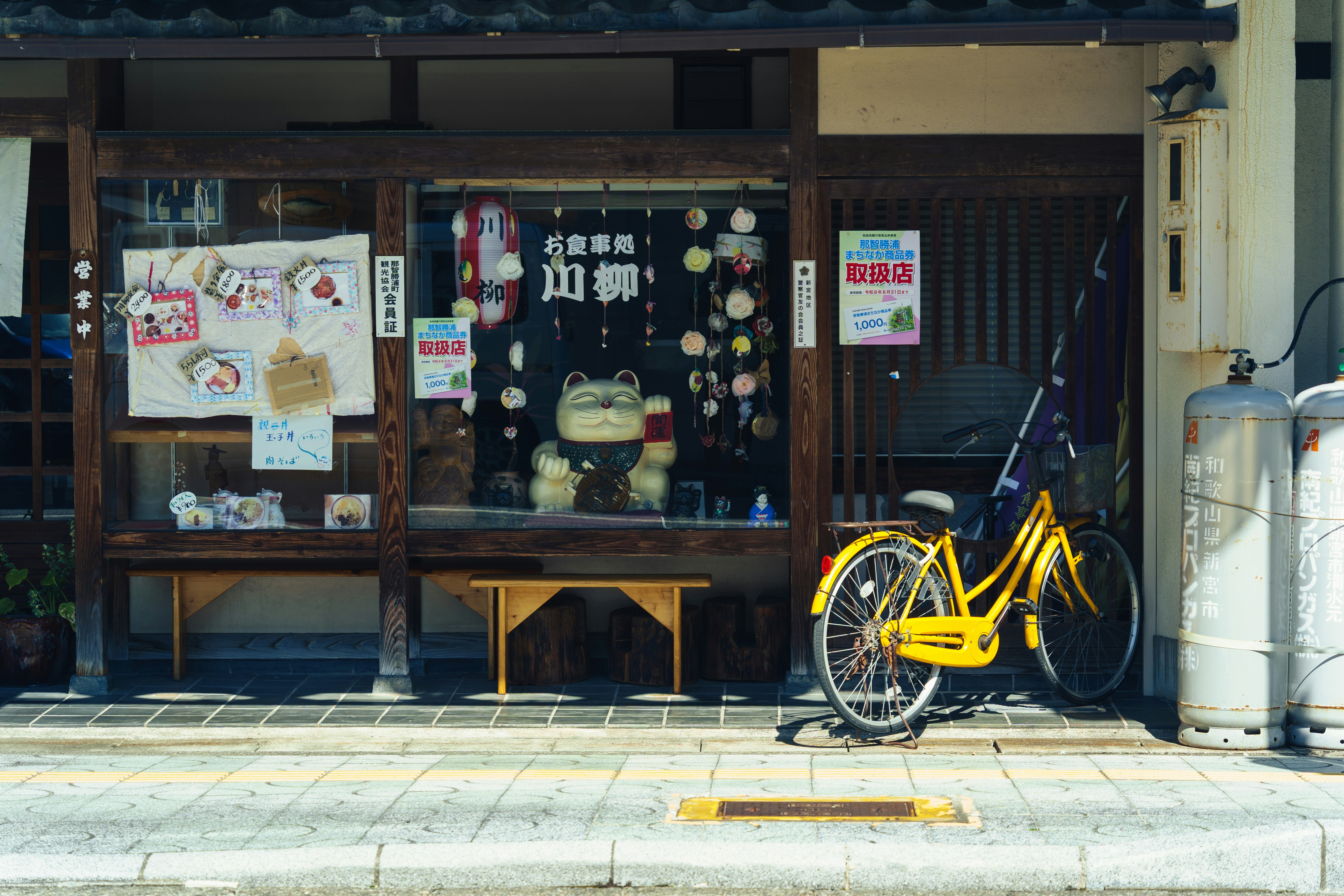 Lucky Cat Shopfront: a sunny urban doorway with a bright yellow bicycle