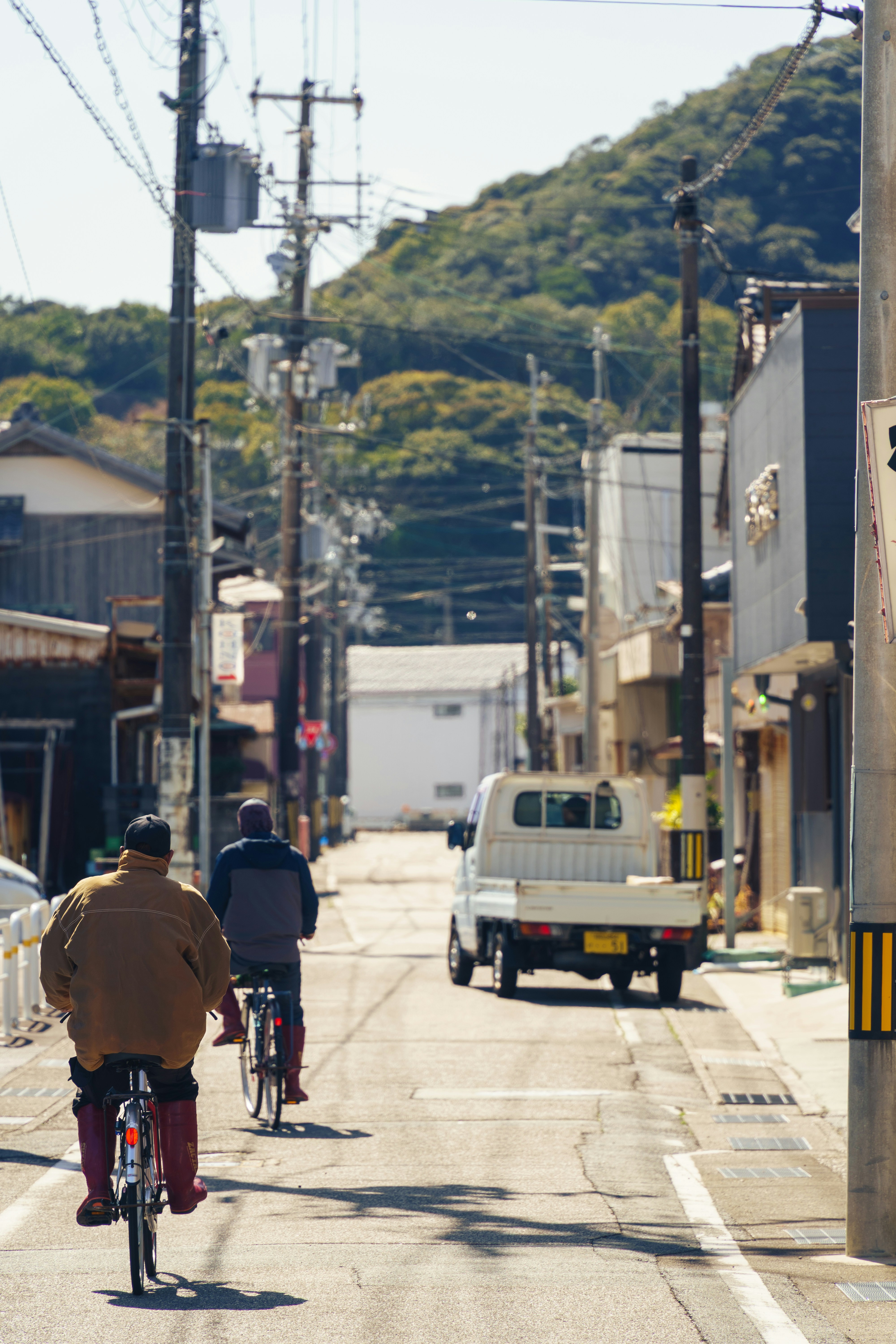 Rural Street Transit: Bicycles and a White Truck Move Through Morning Light