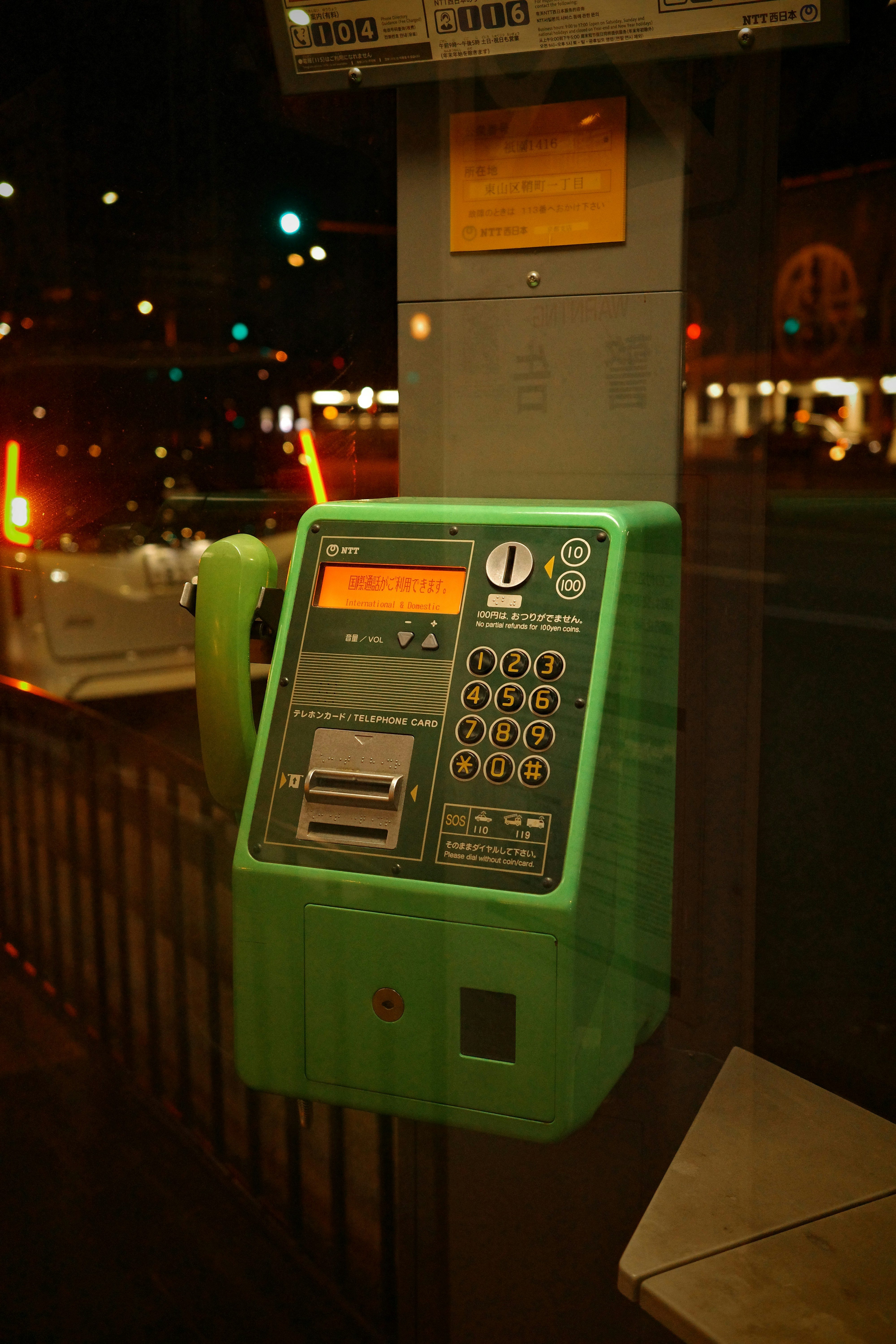 Green Pay Terminal at Night: Reflections and Neon Sparks