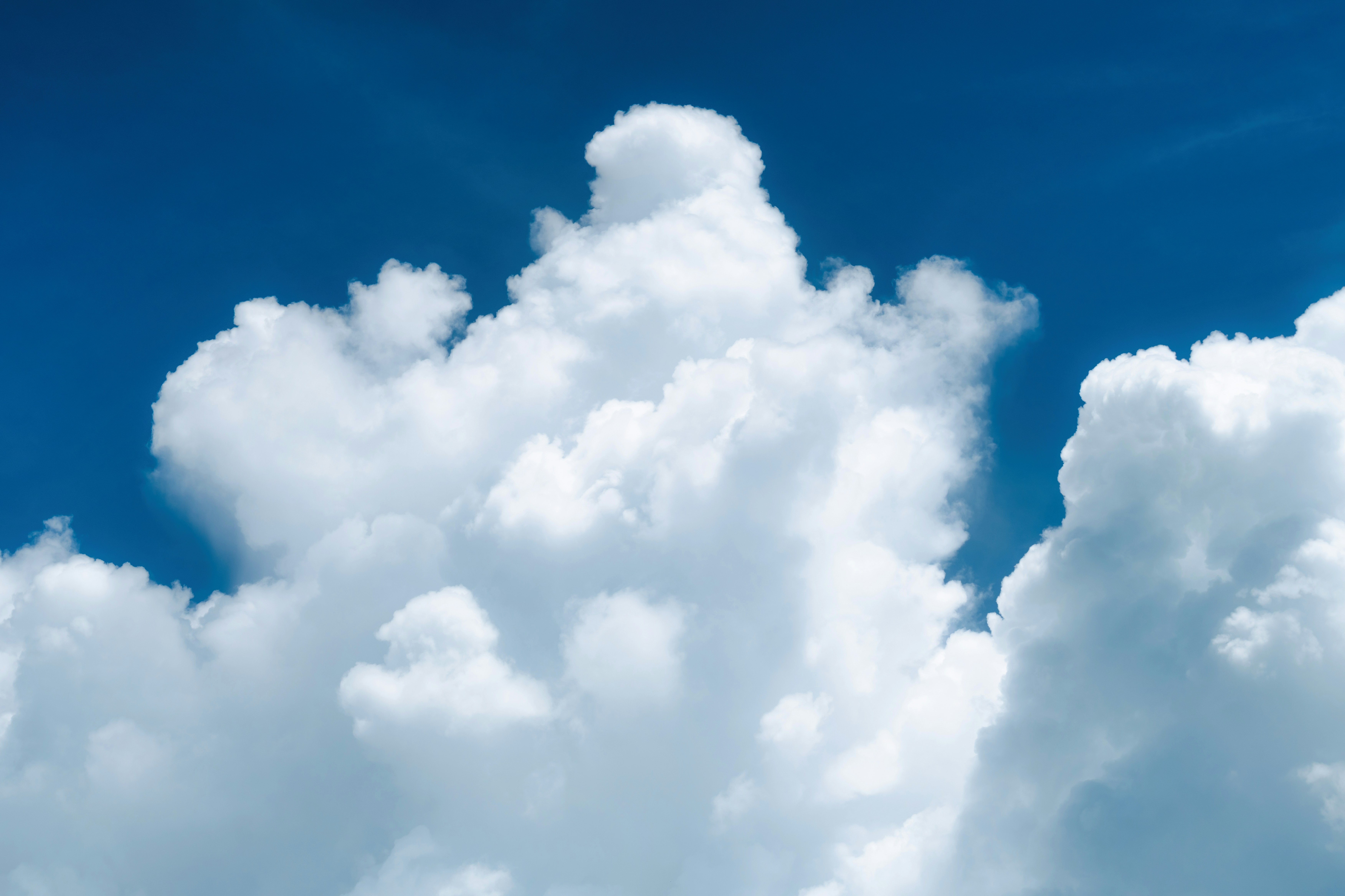 Blue-Sky Summit: A Majestic Cloud Slice Rising above the Horizon