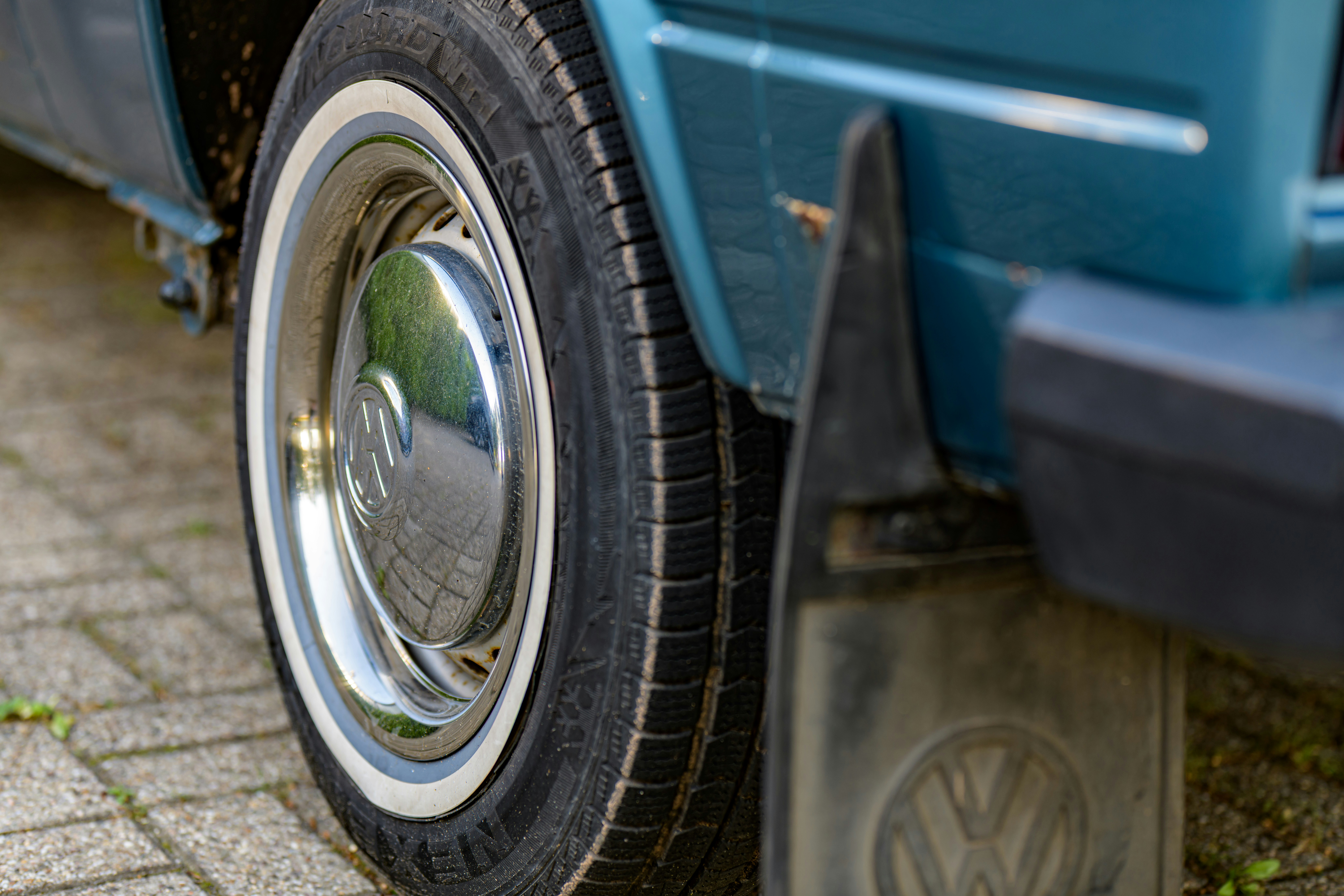 Chrome hubcap glint in the shade of a vintage blue wheel