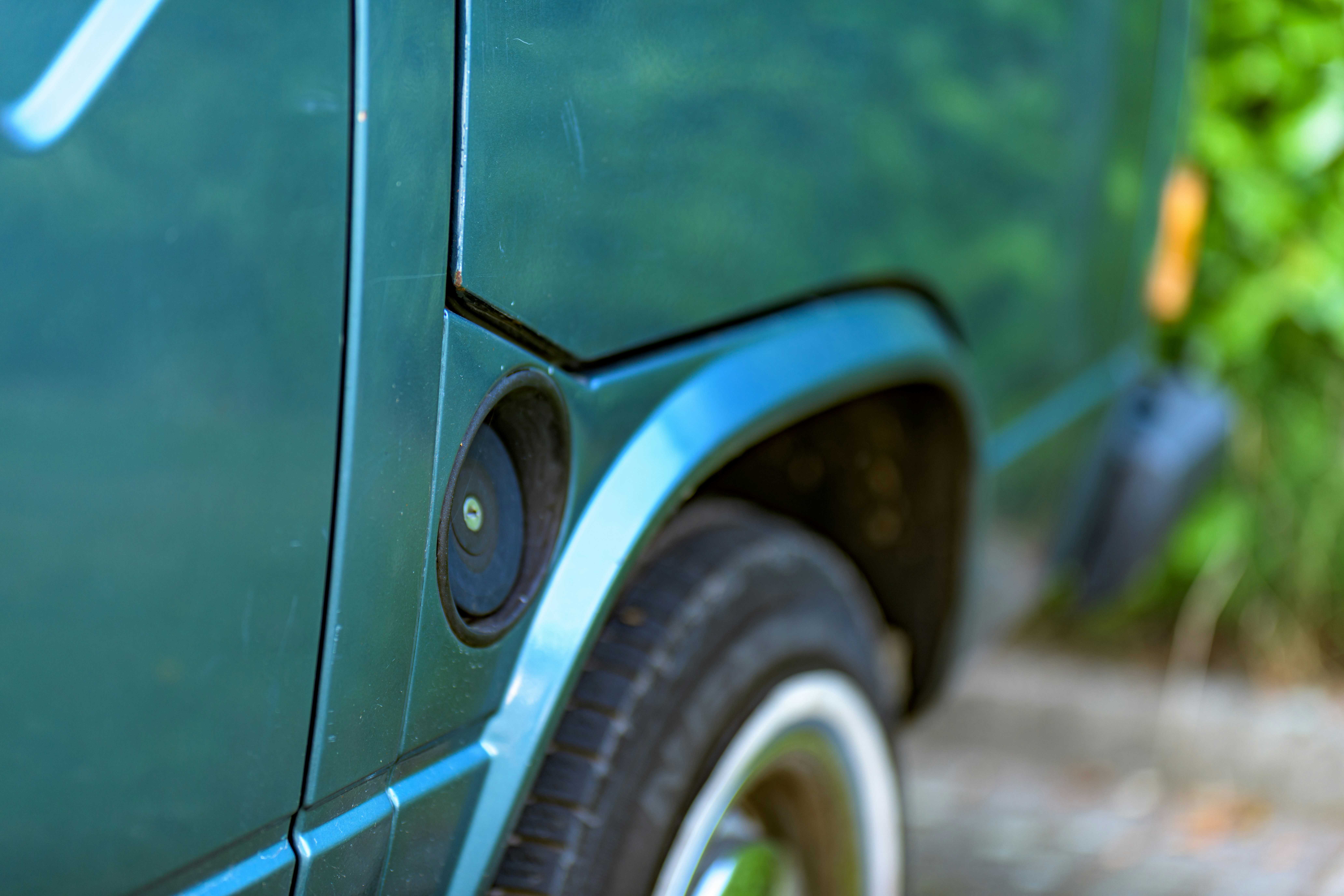 Charred Green Van Wheelwell: A Close-Up on a Subtle Vehicle Element