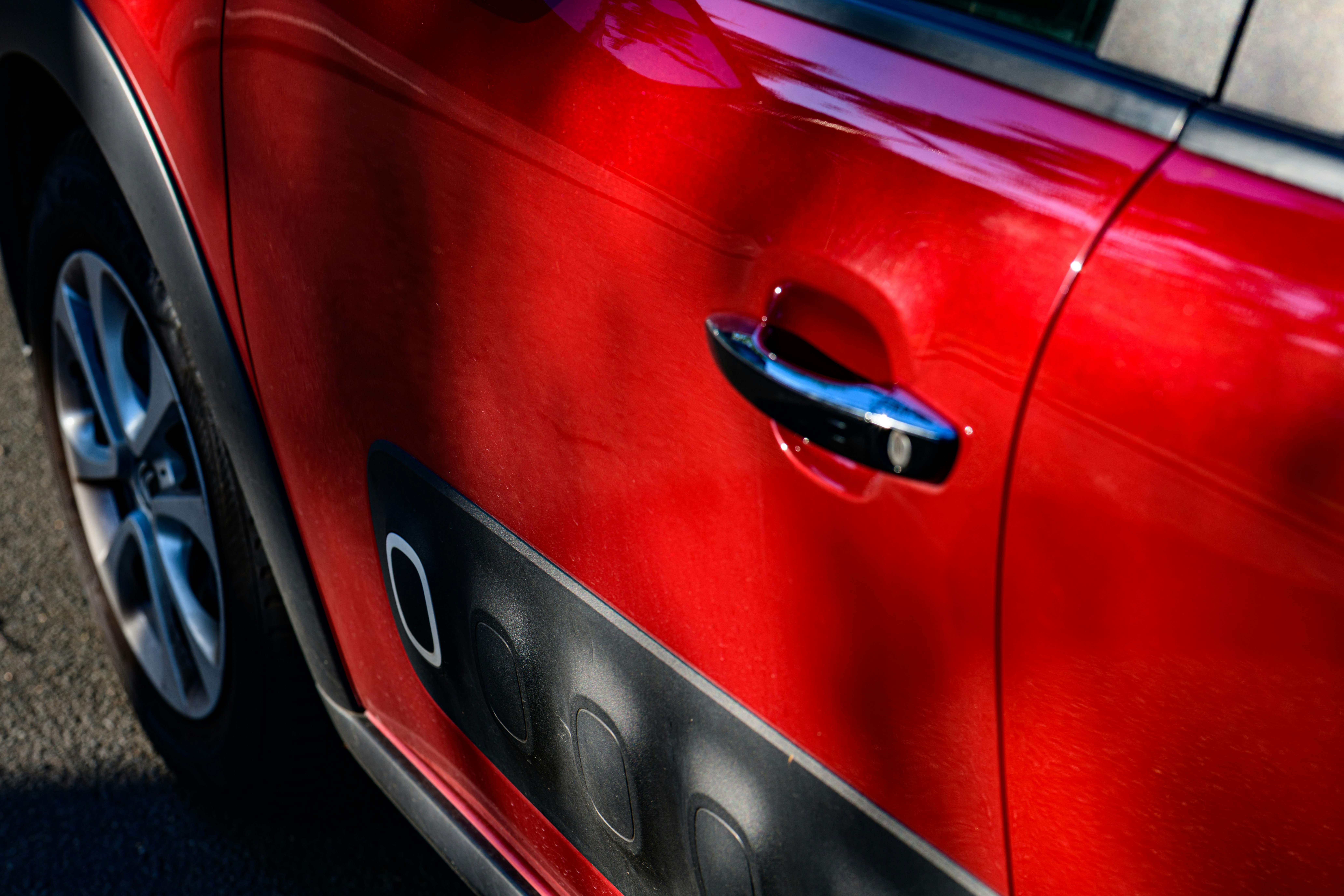 Crimson Side Panel: A Sunlit Car Door in Sharp Focus