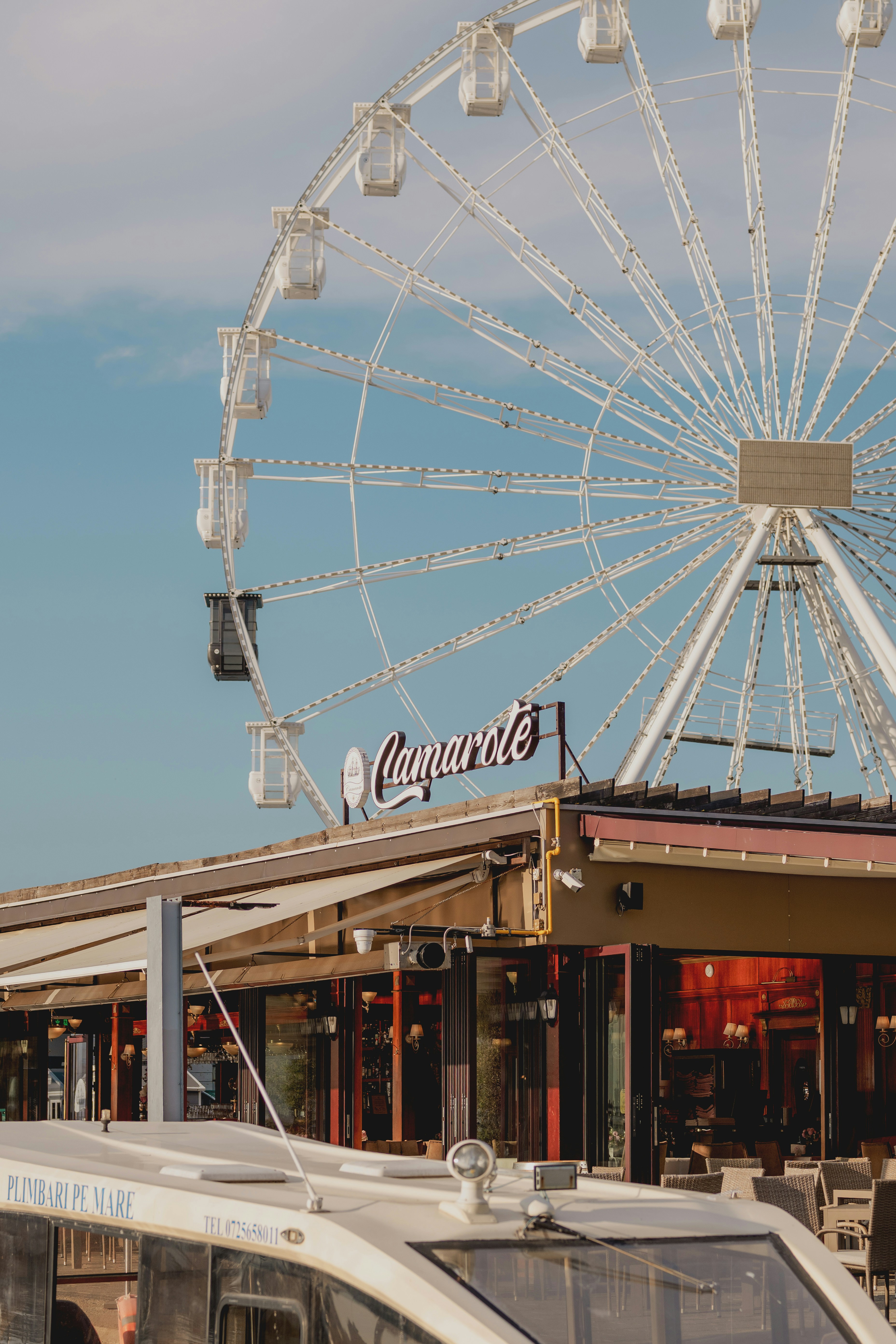 Ferris Wheel Over Shops: Neon Sign and Lanterns at Seaside Amusement