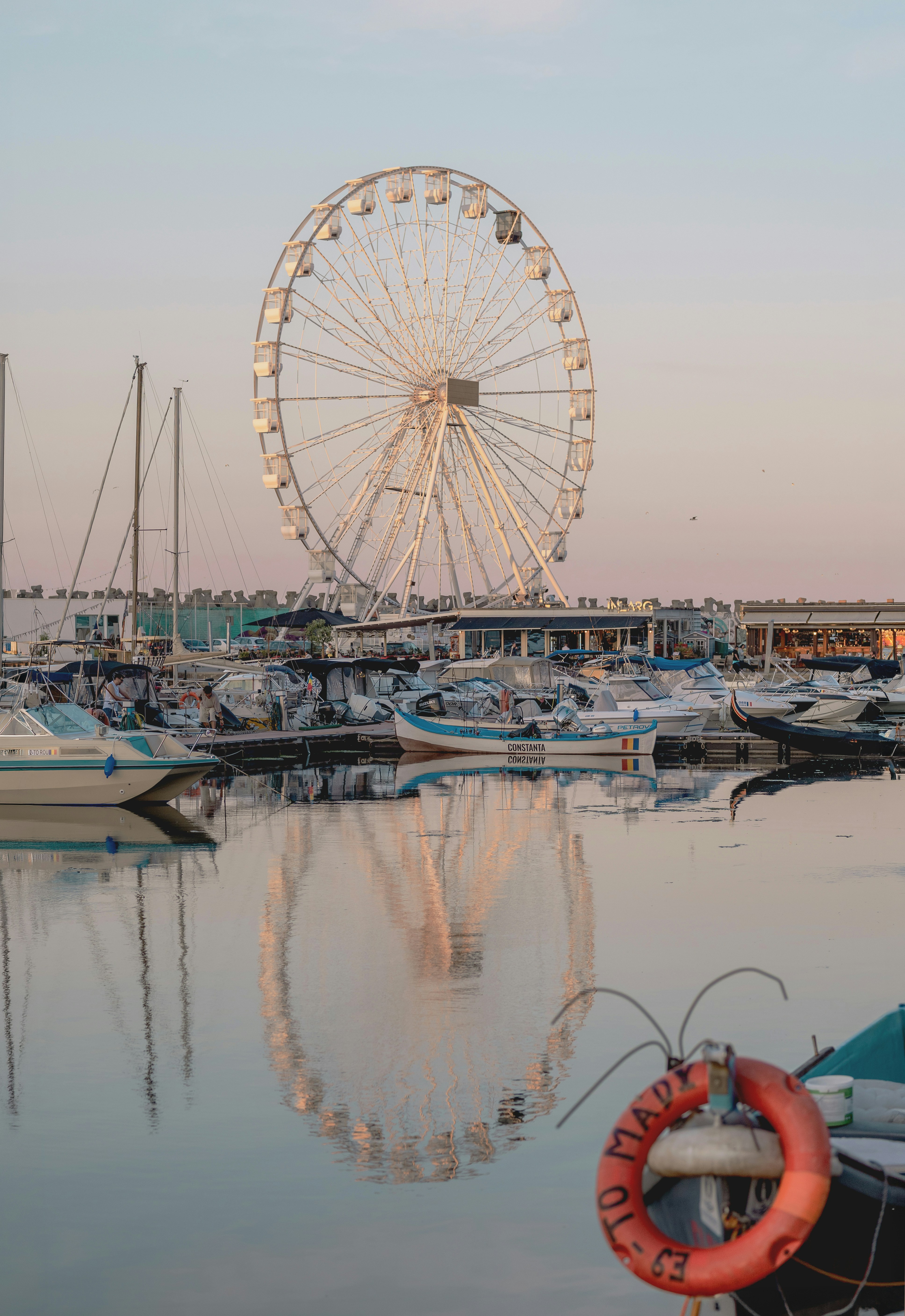Moonlight Marina: Ferris Wheel at Sunset Over Quiet Boats