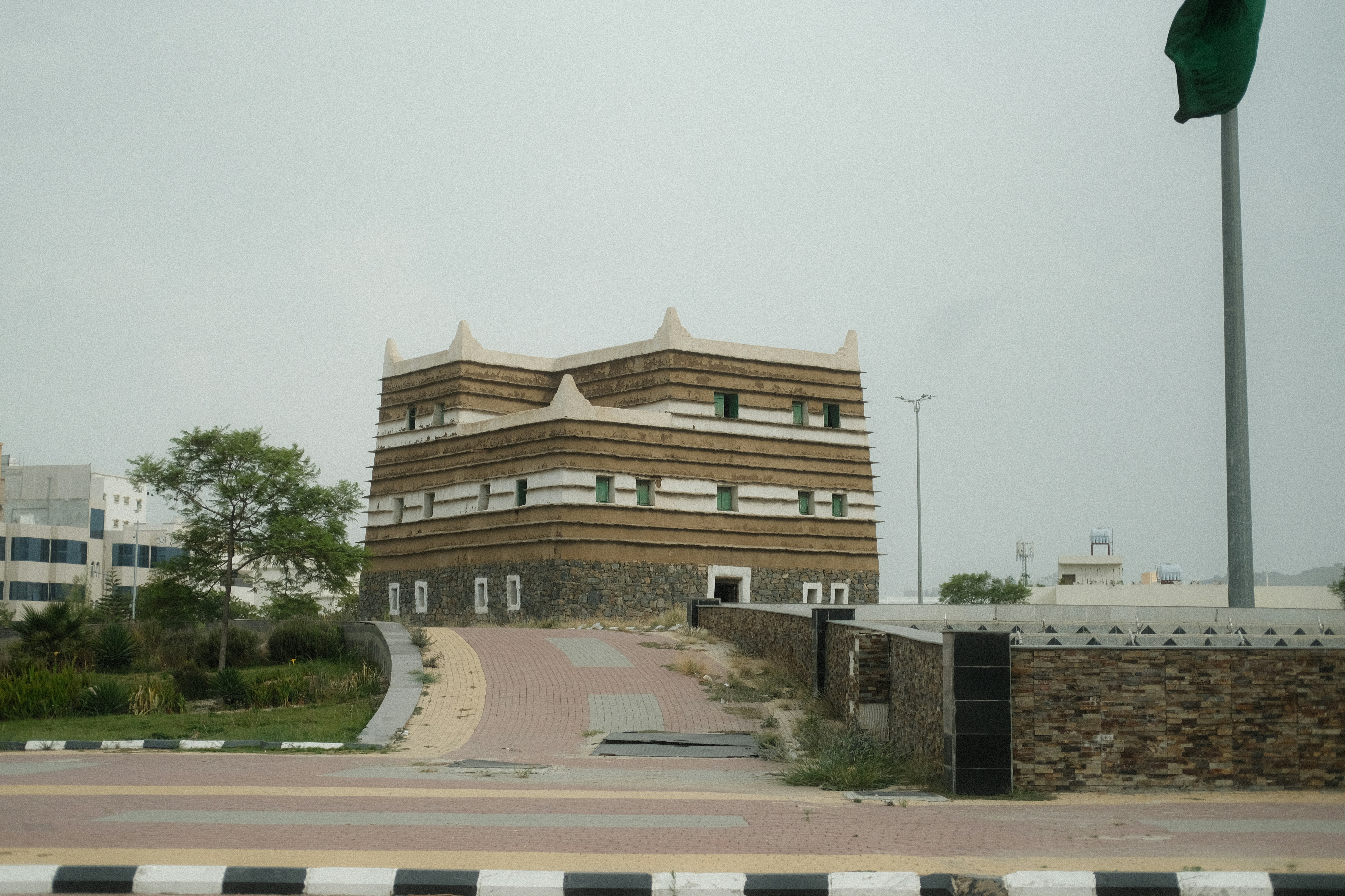 Modernized fortress: layered brick structure at hillside plaza