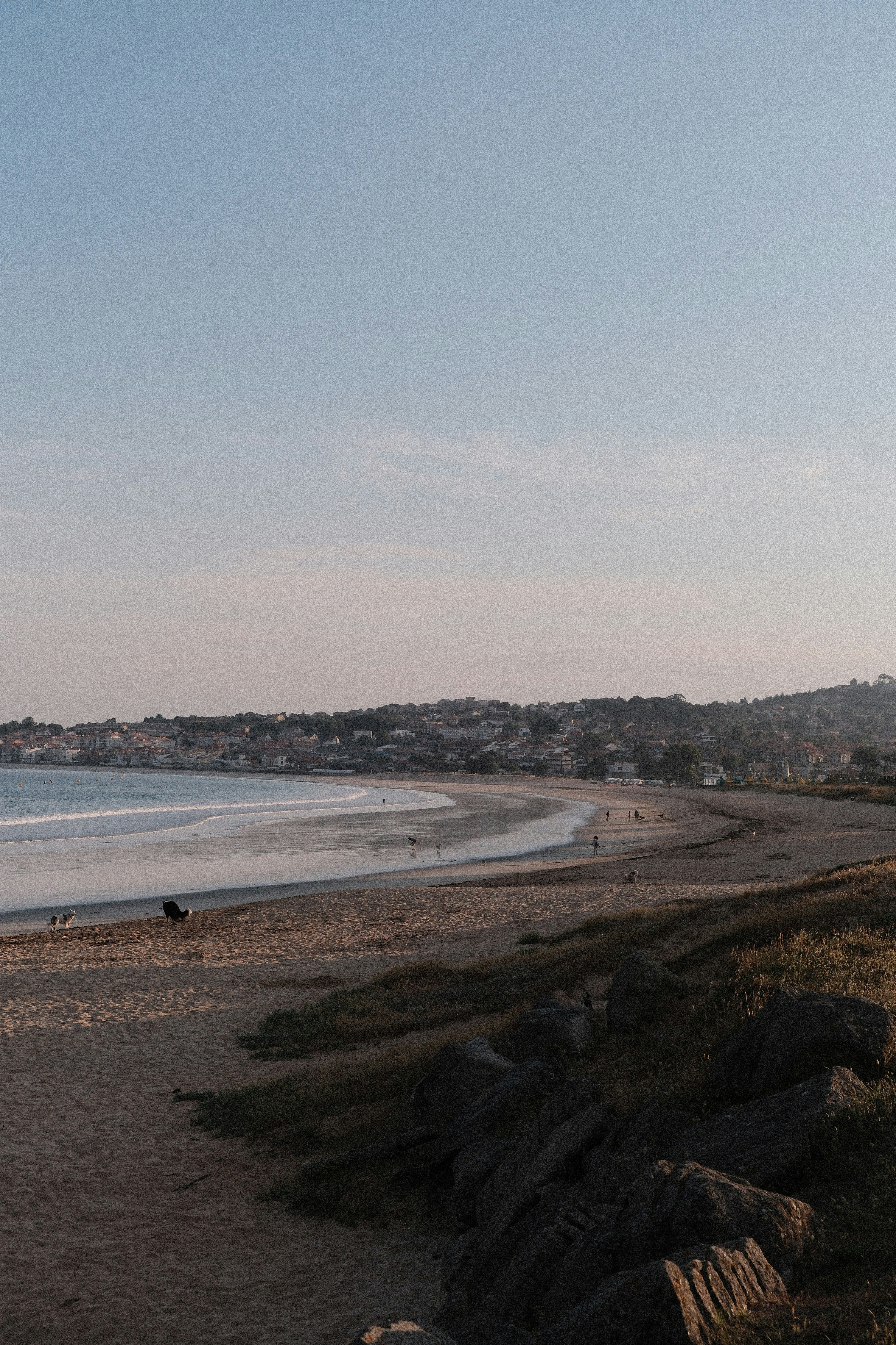 Sunlit Crescent: Quiet Shoreline with Distant Town