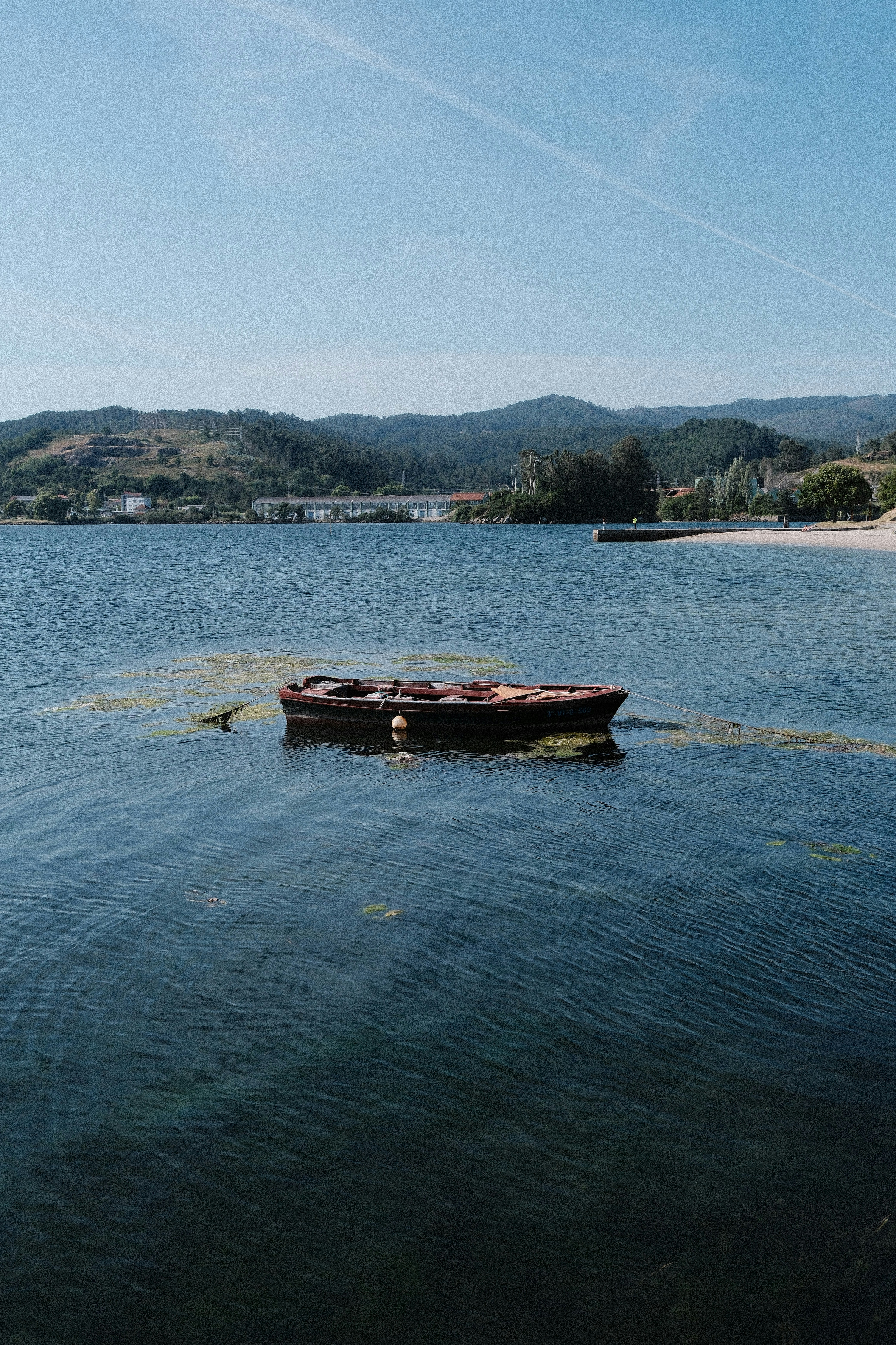 Lonely Rowboat on a Tranquil Lake under a Clear Sky